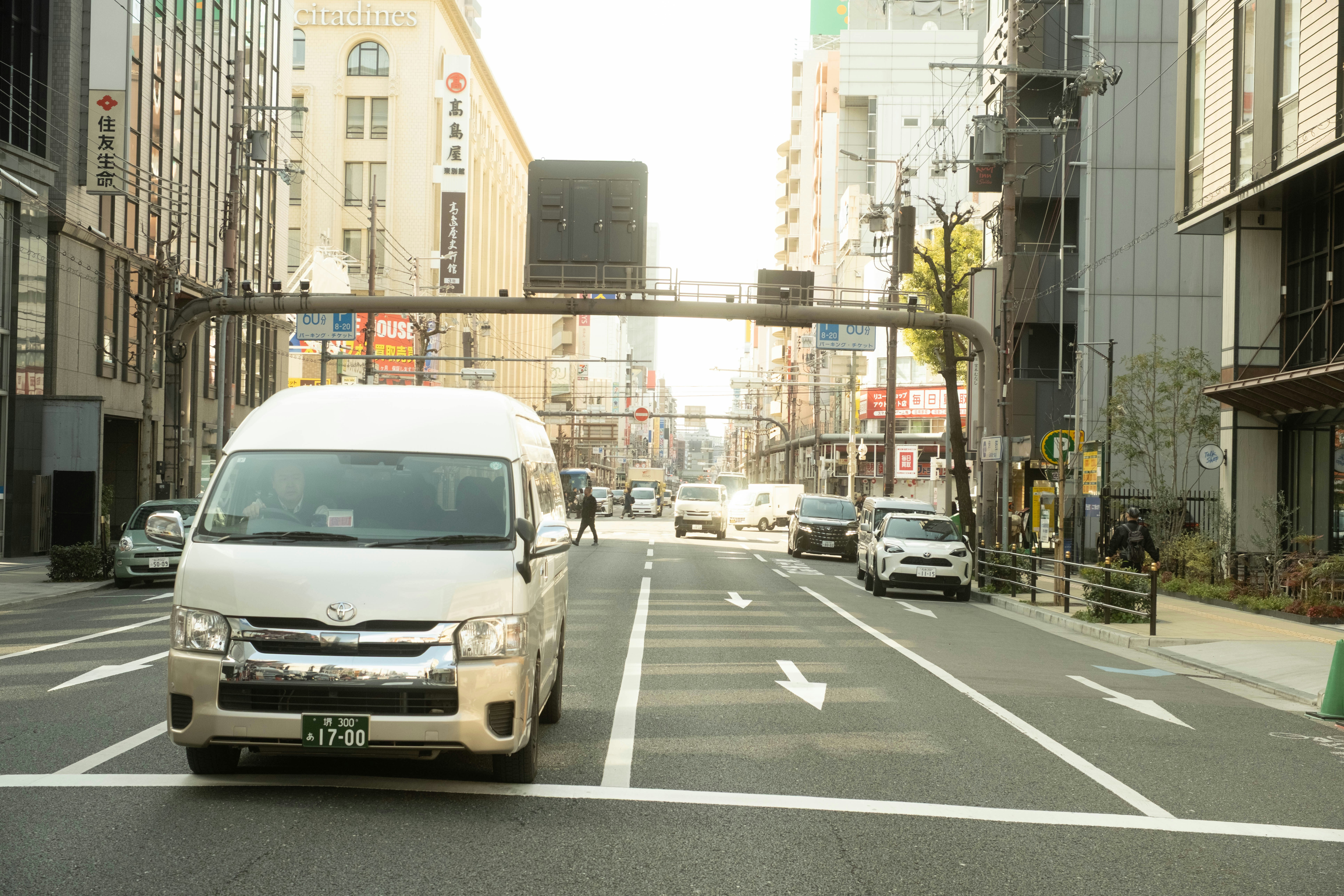 Midtown Corridor: White Delivery Van Leads a Quiet Morning Street