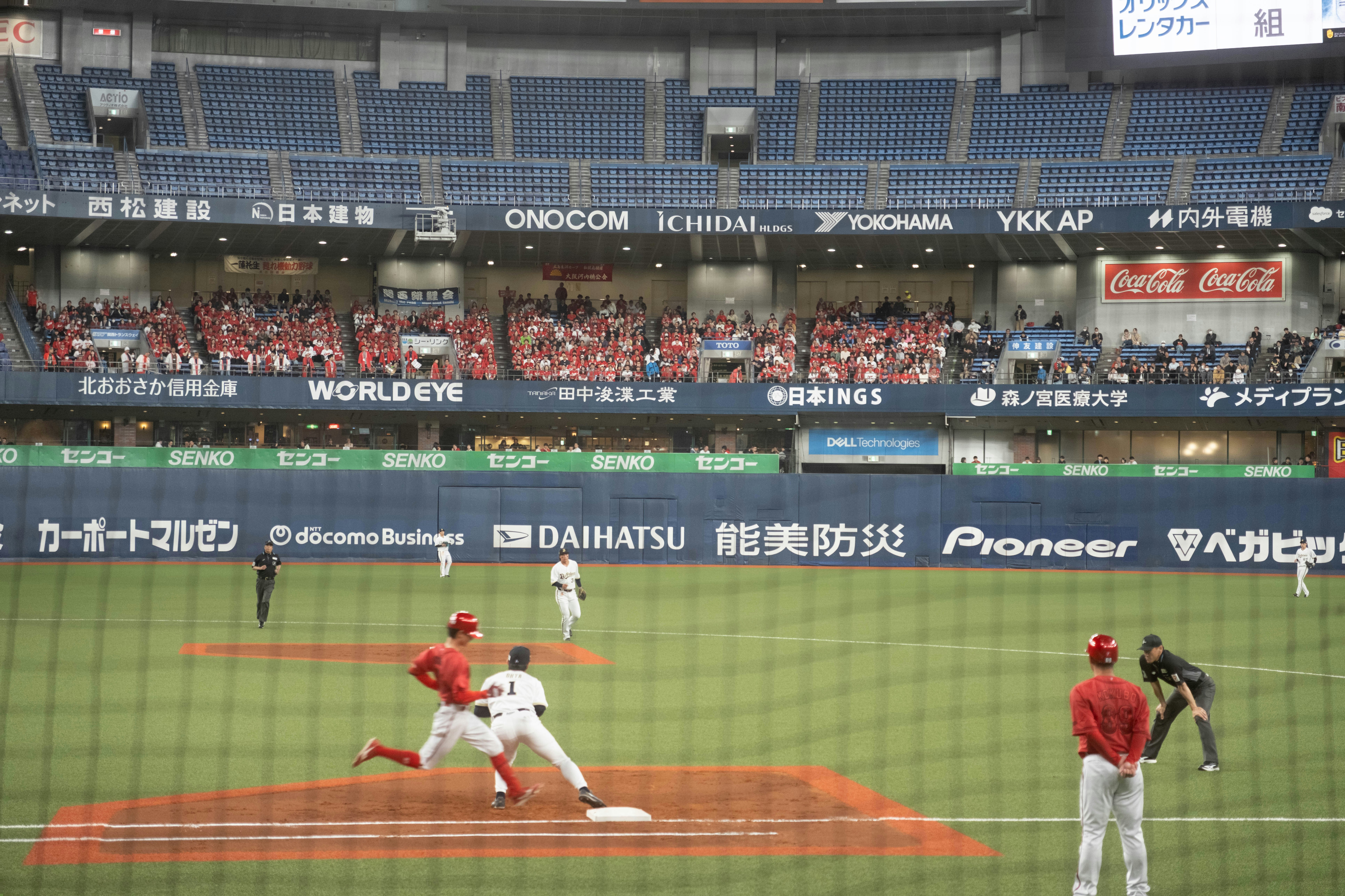 Red-jersey Pitcher in Mid-Throw under Stadium Lights