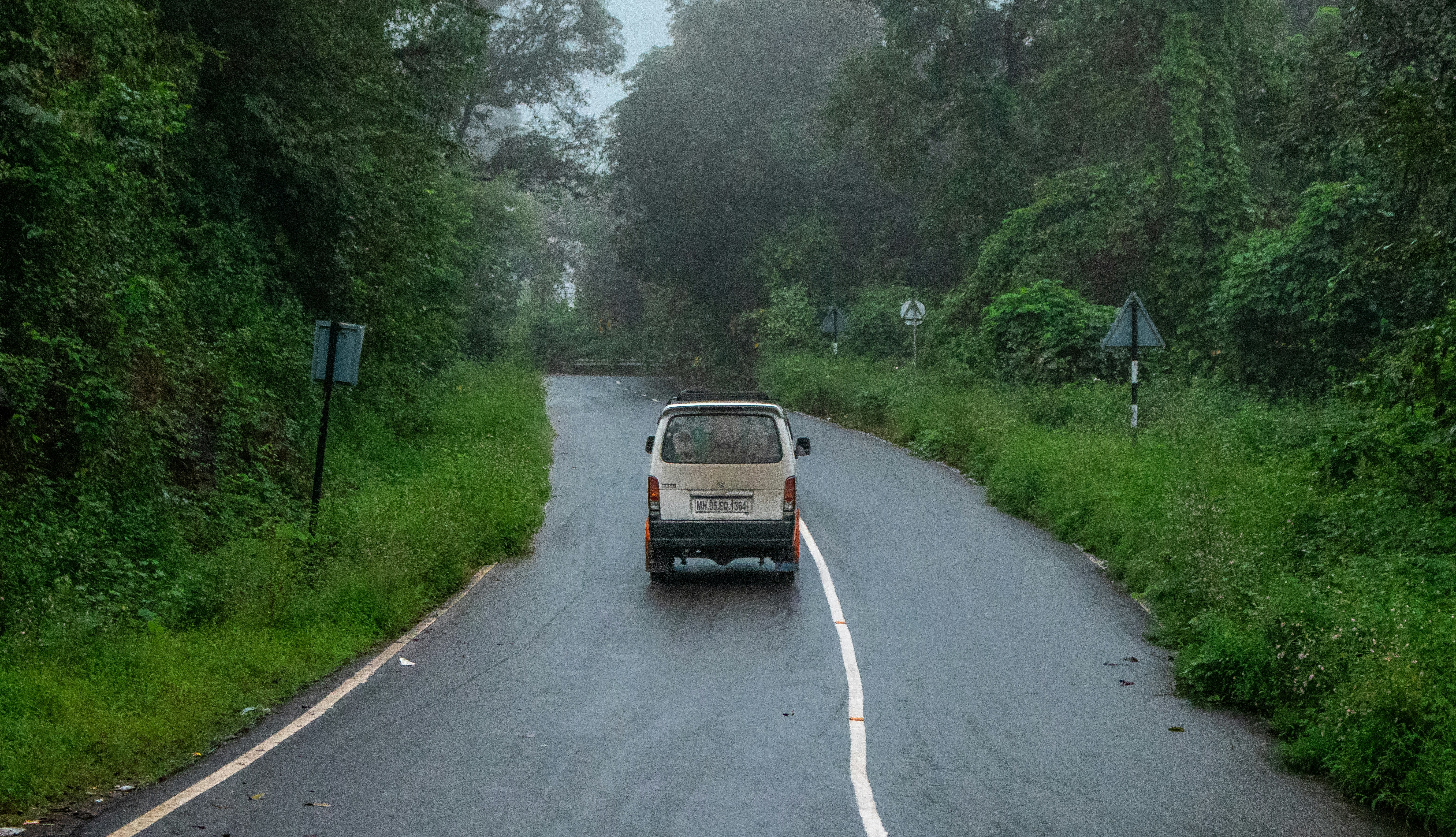 Quiet Rain-Slick Road: A Distant Van Conveys a Hushed Journey