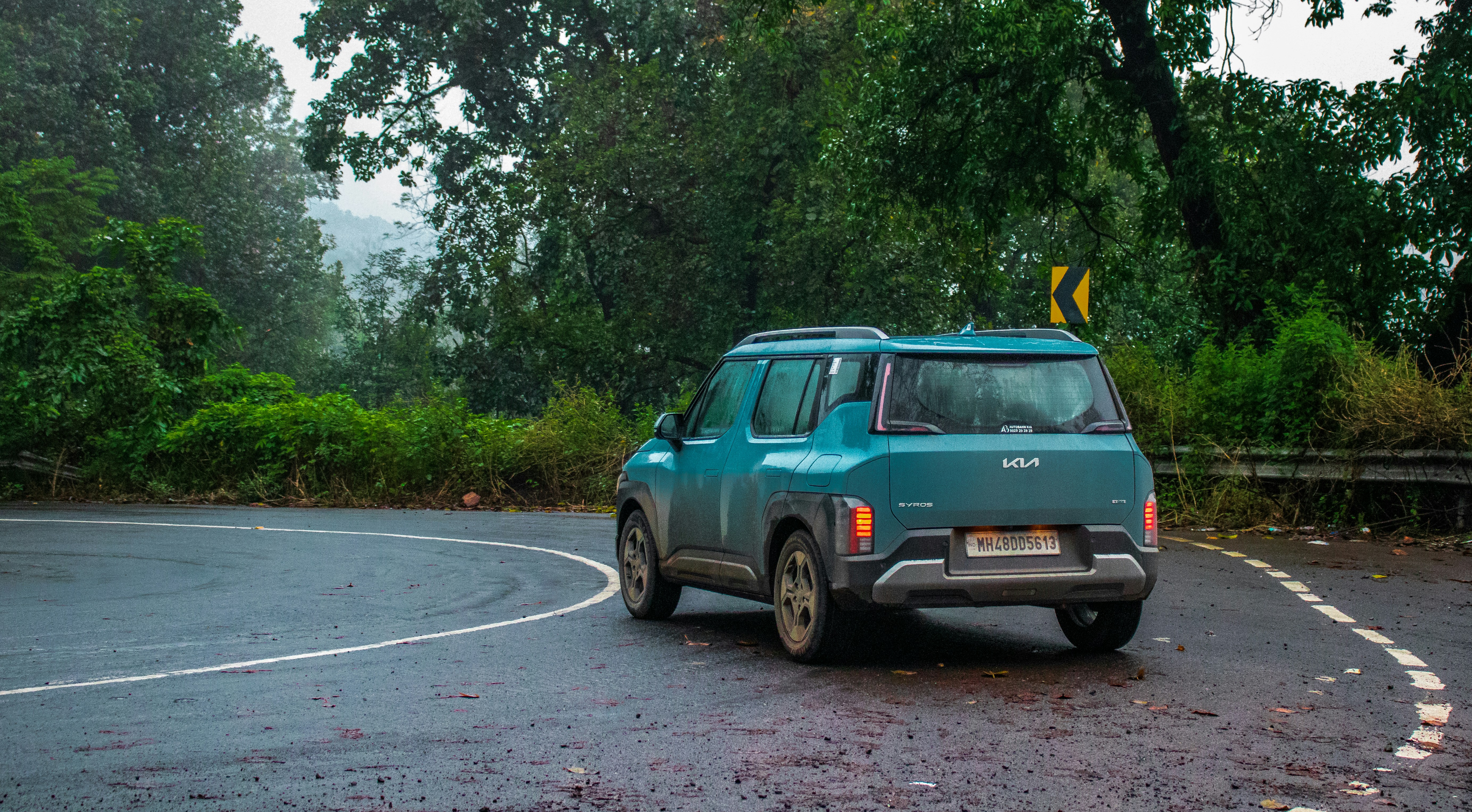Blue SUV on a Wet Curved Road Reclaiming the Scenic Route