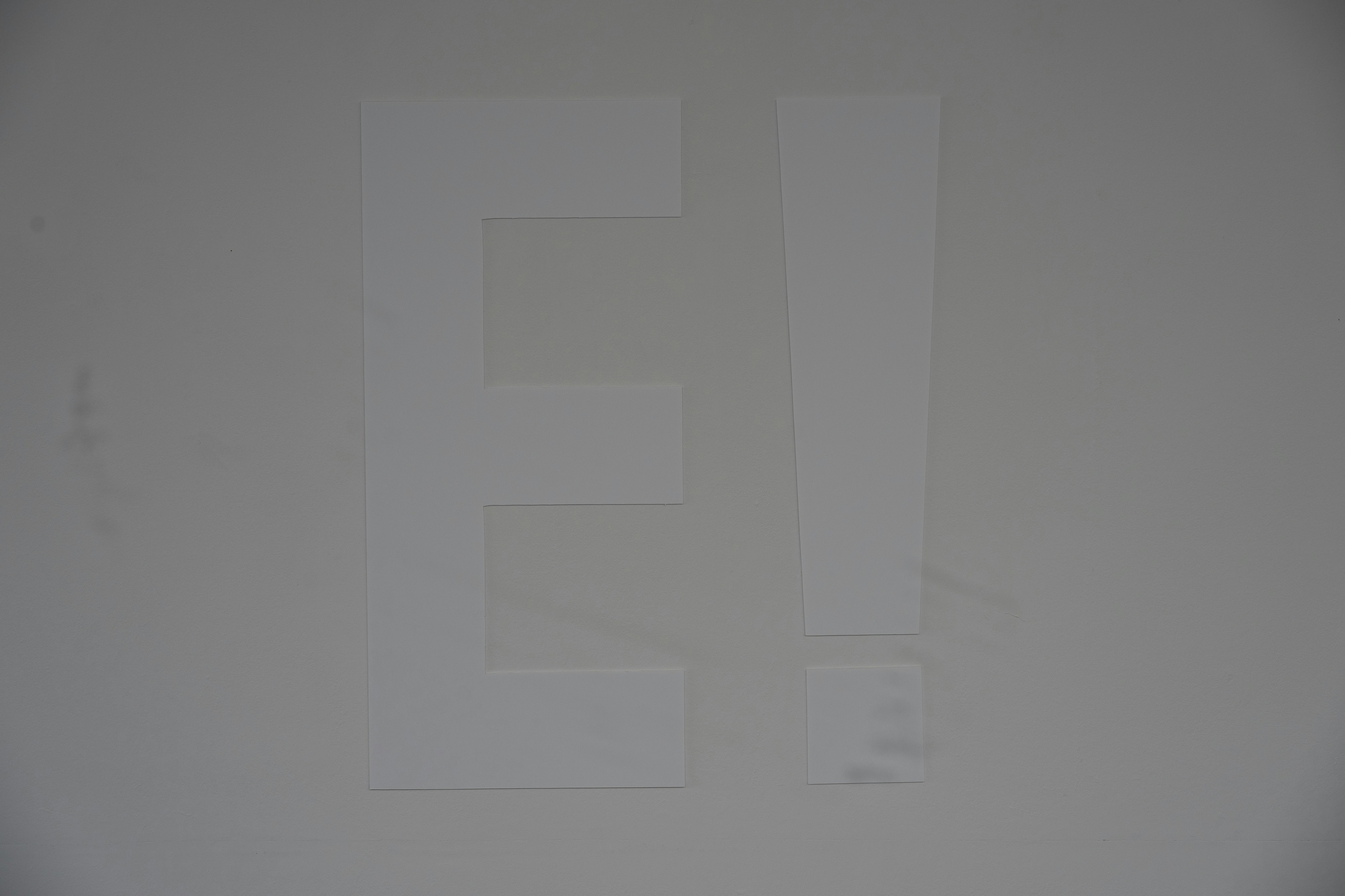 Soft Shadow of a Cut-Out Logo on a Gray Surface
