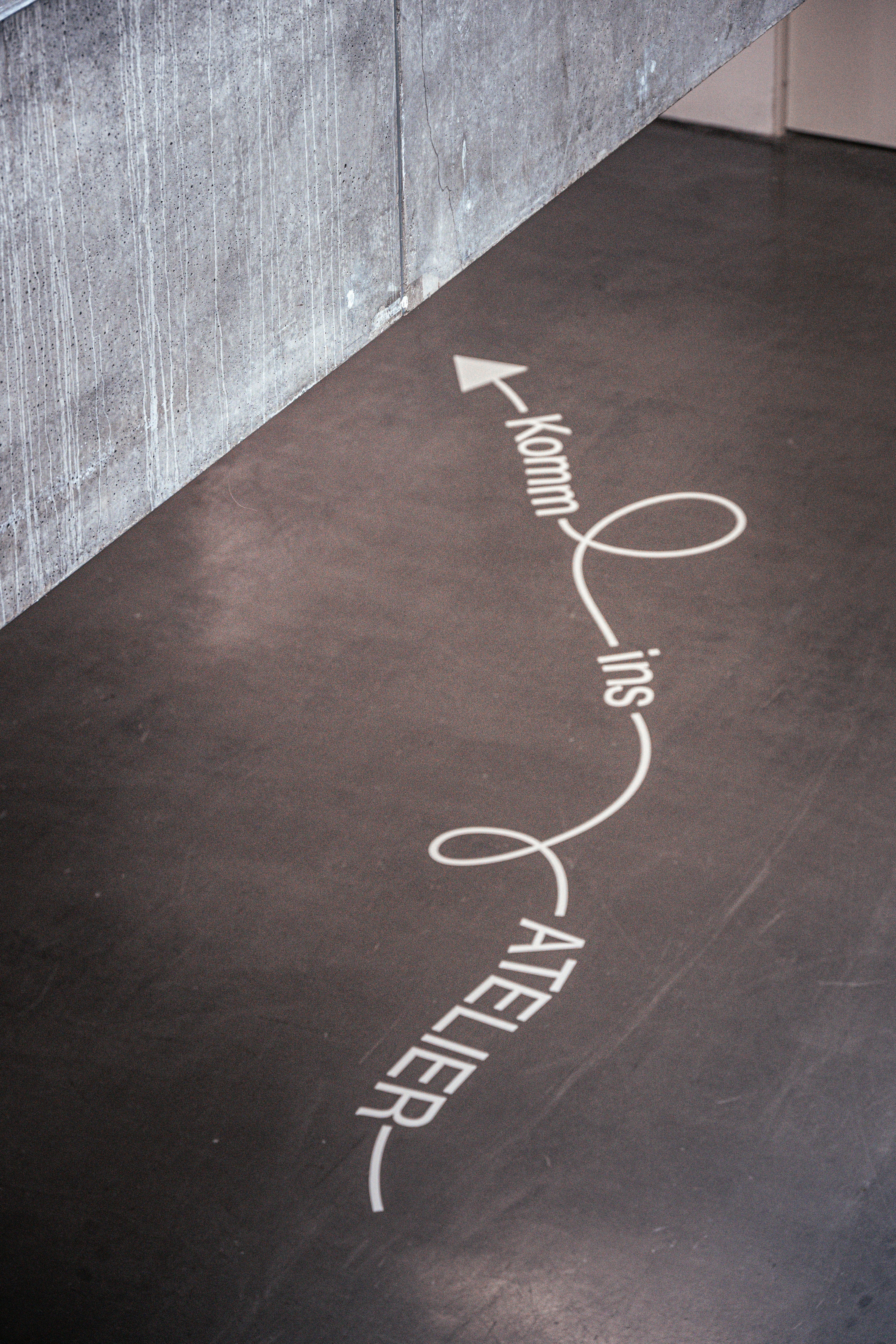 Whispering Path: A Curved Script on a Concrete Floor