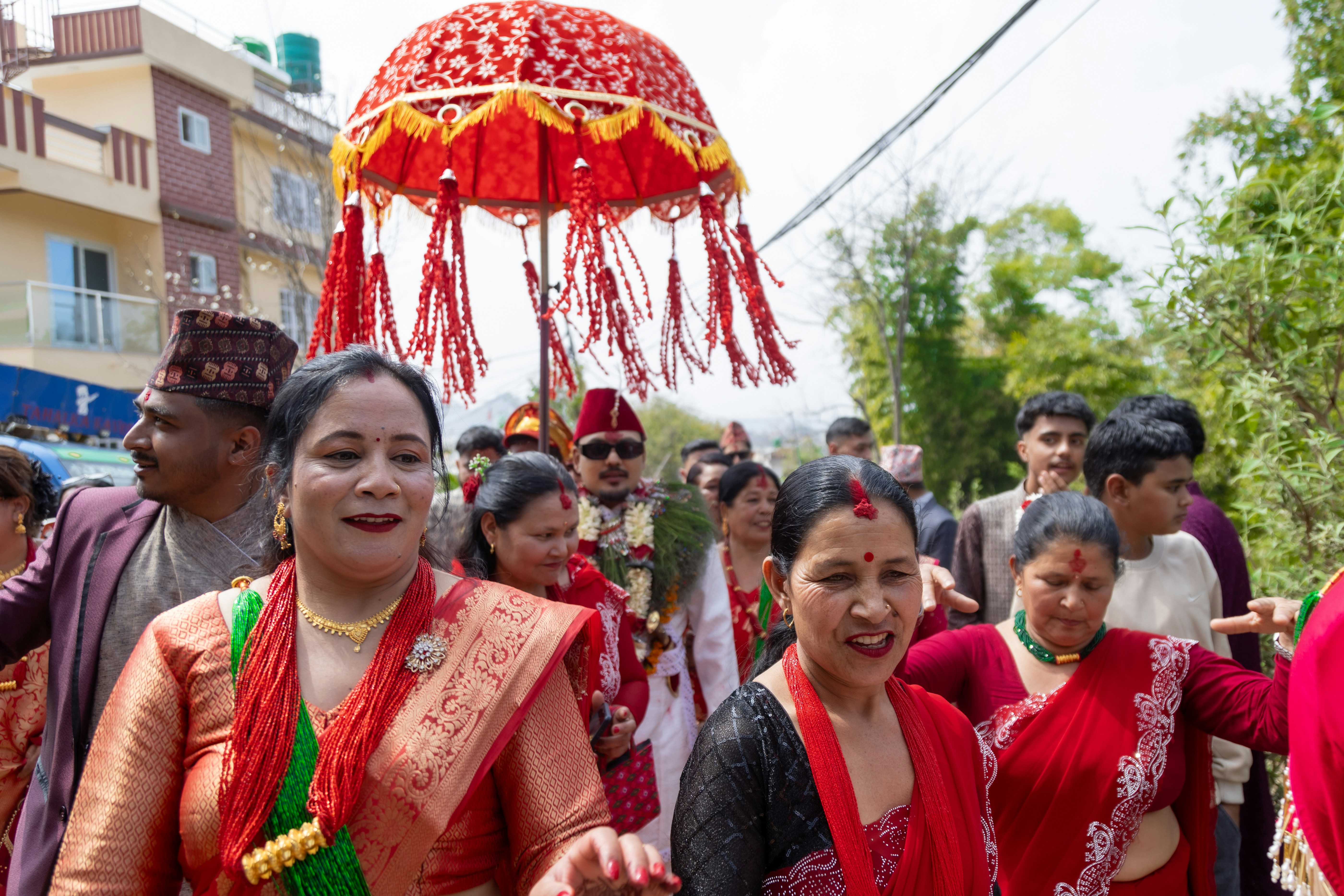 Festival procession under a red fringed parasol