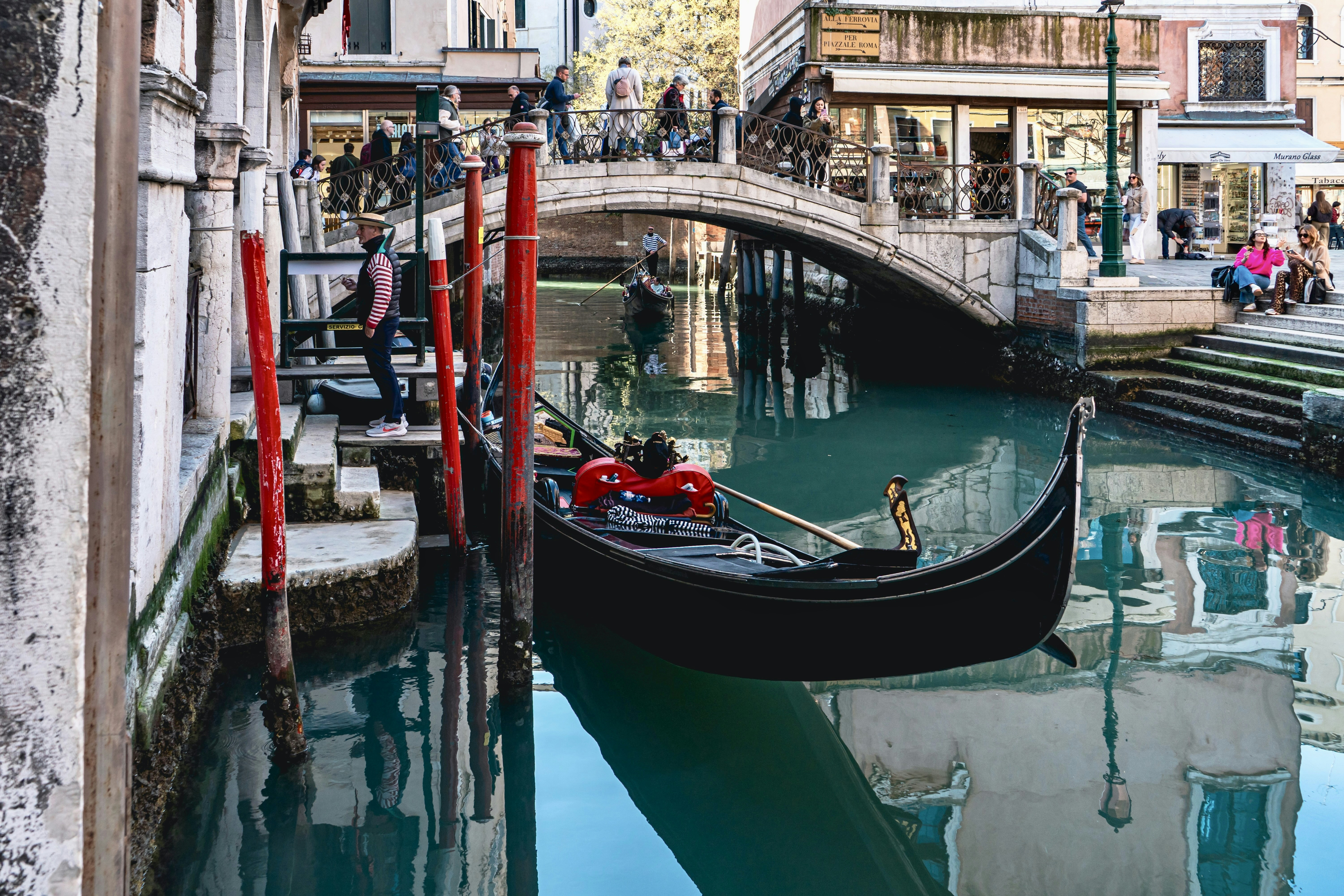 Gondola Rest at a Venetian Channel Under a Stone Bridge