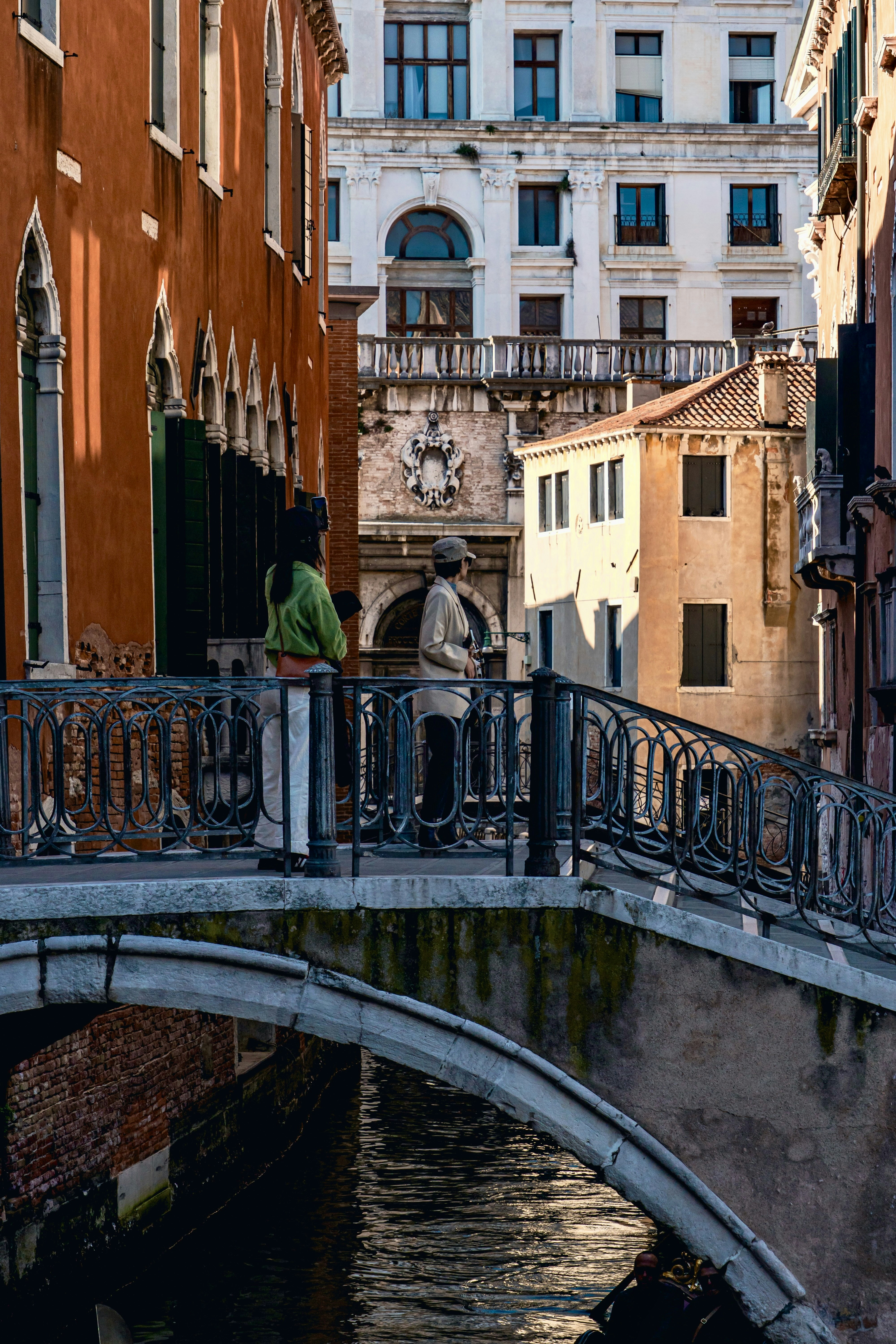  bridged conversation in a sunlit Venetian alley
