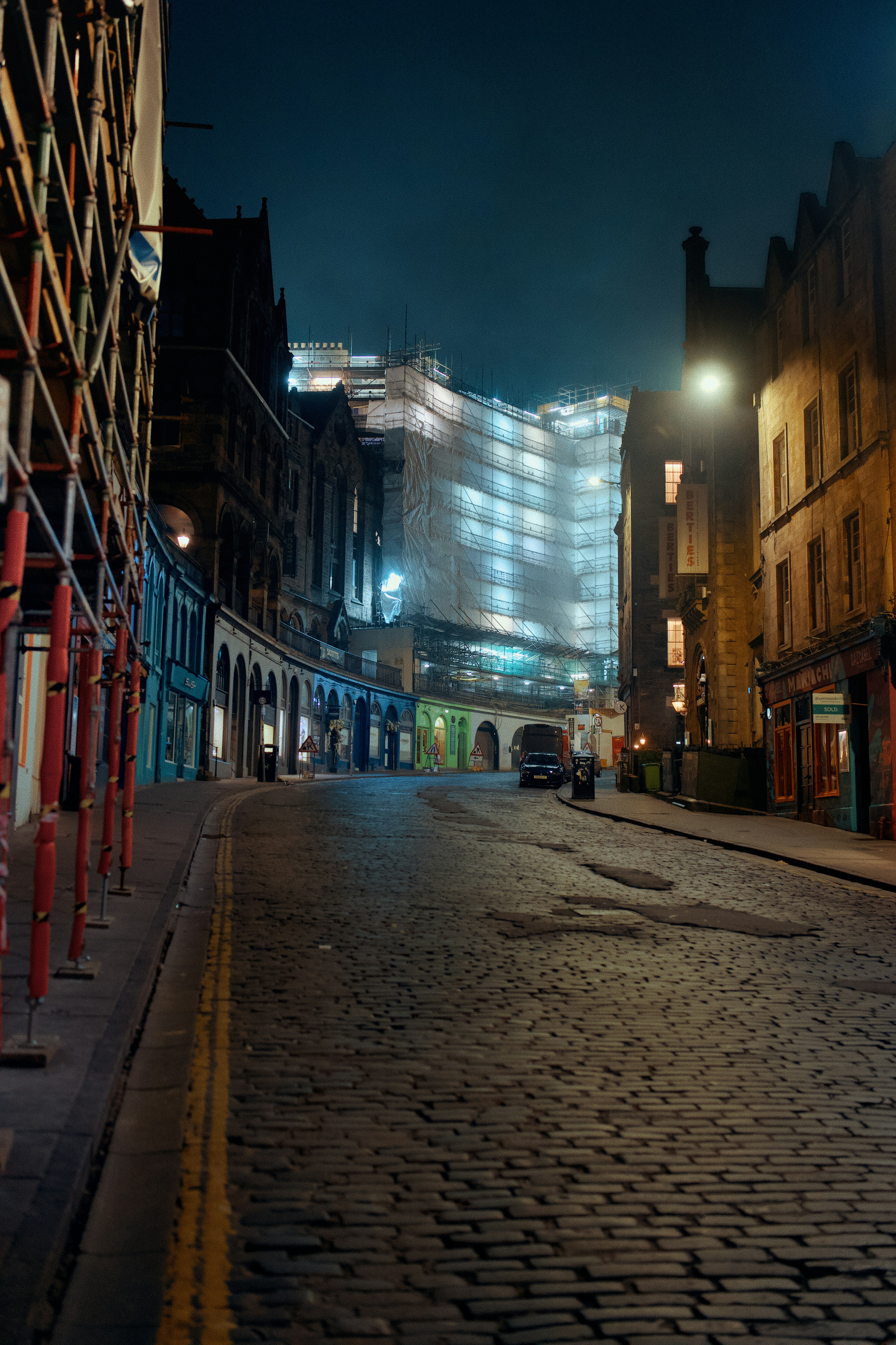 Night Street Under Construction: Warm Lights and Cobblestones