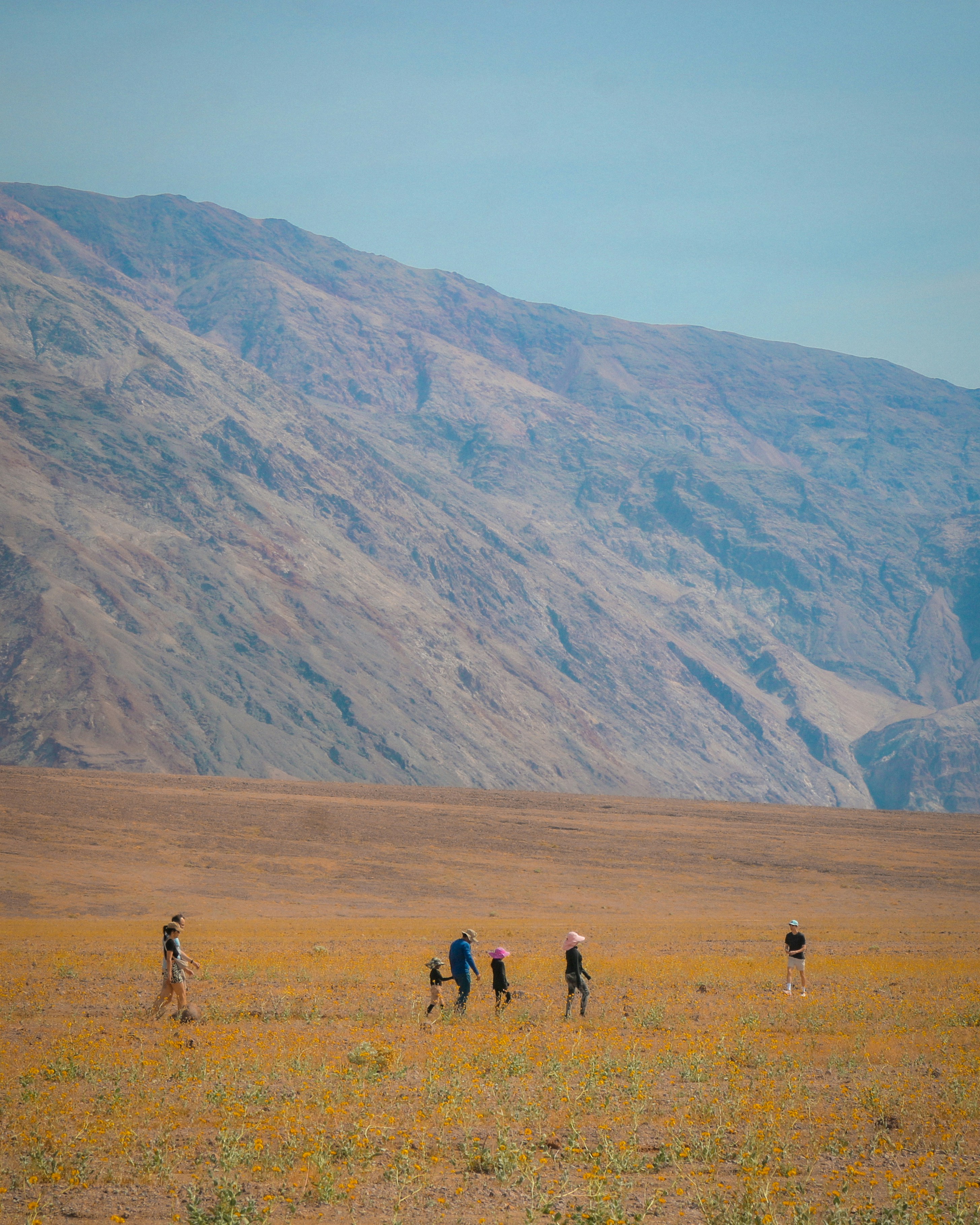 Dusty Plain Trek: A Line of Wanderers Amidst Sierra Lines