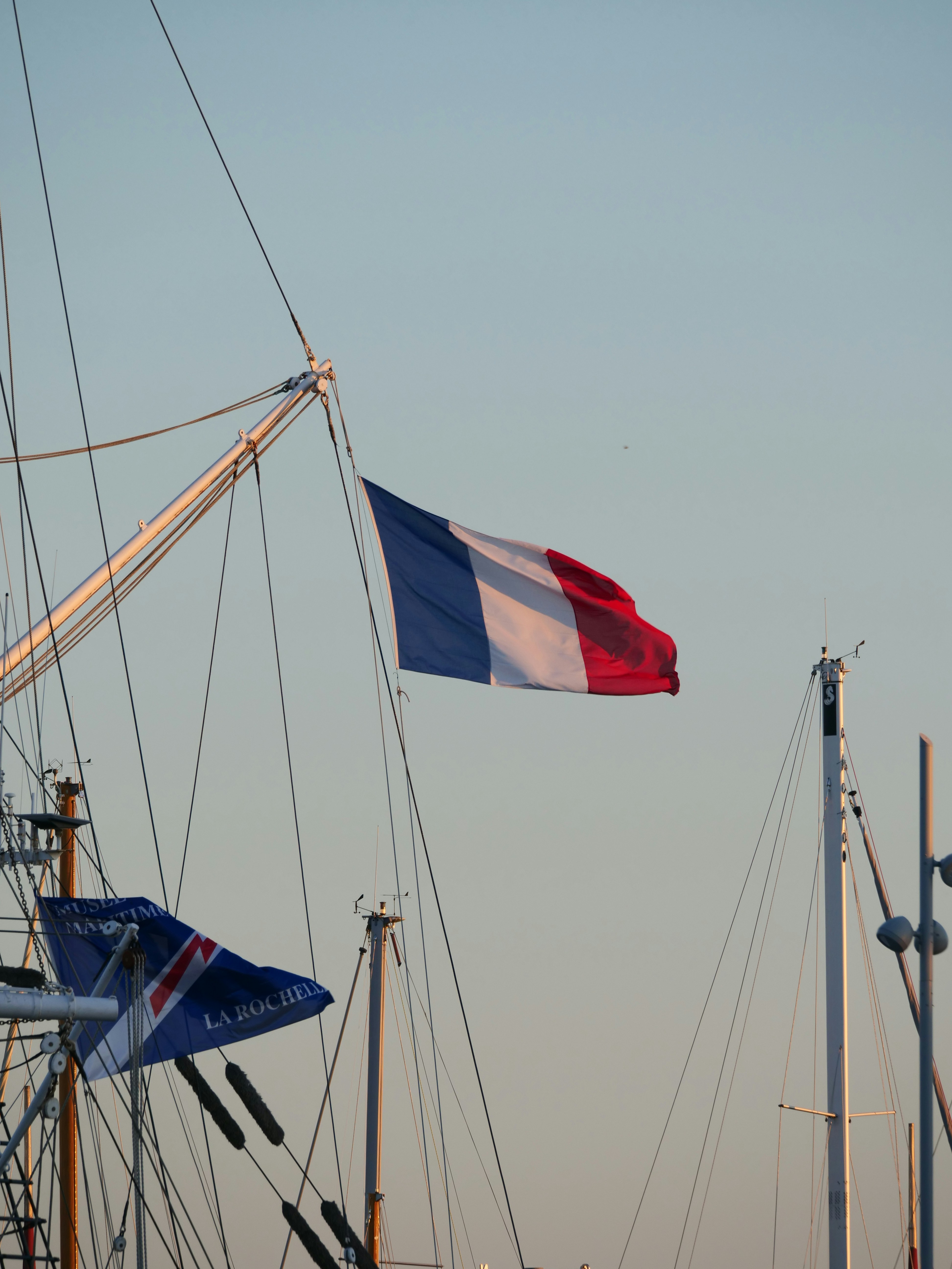 Flag of France Basking Above a Sailboat Mast