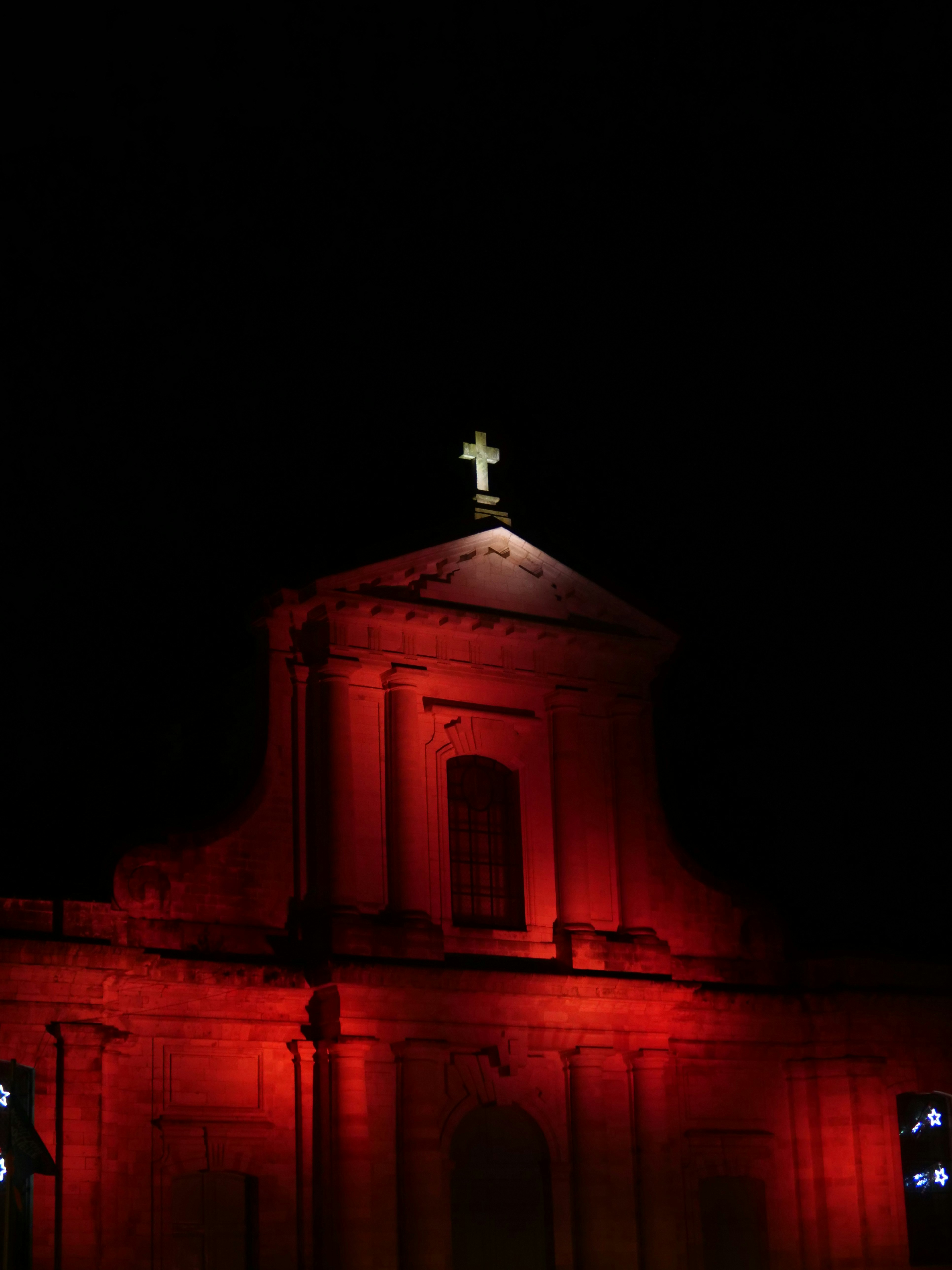 Crimson Majority: A Red-lit Chapel Emerges from Night