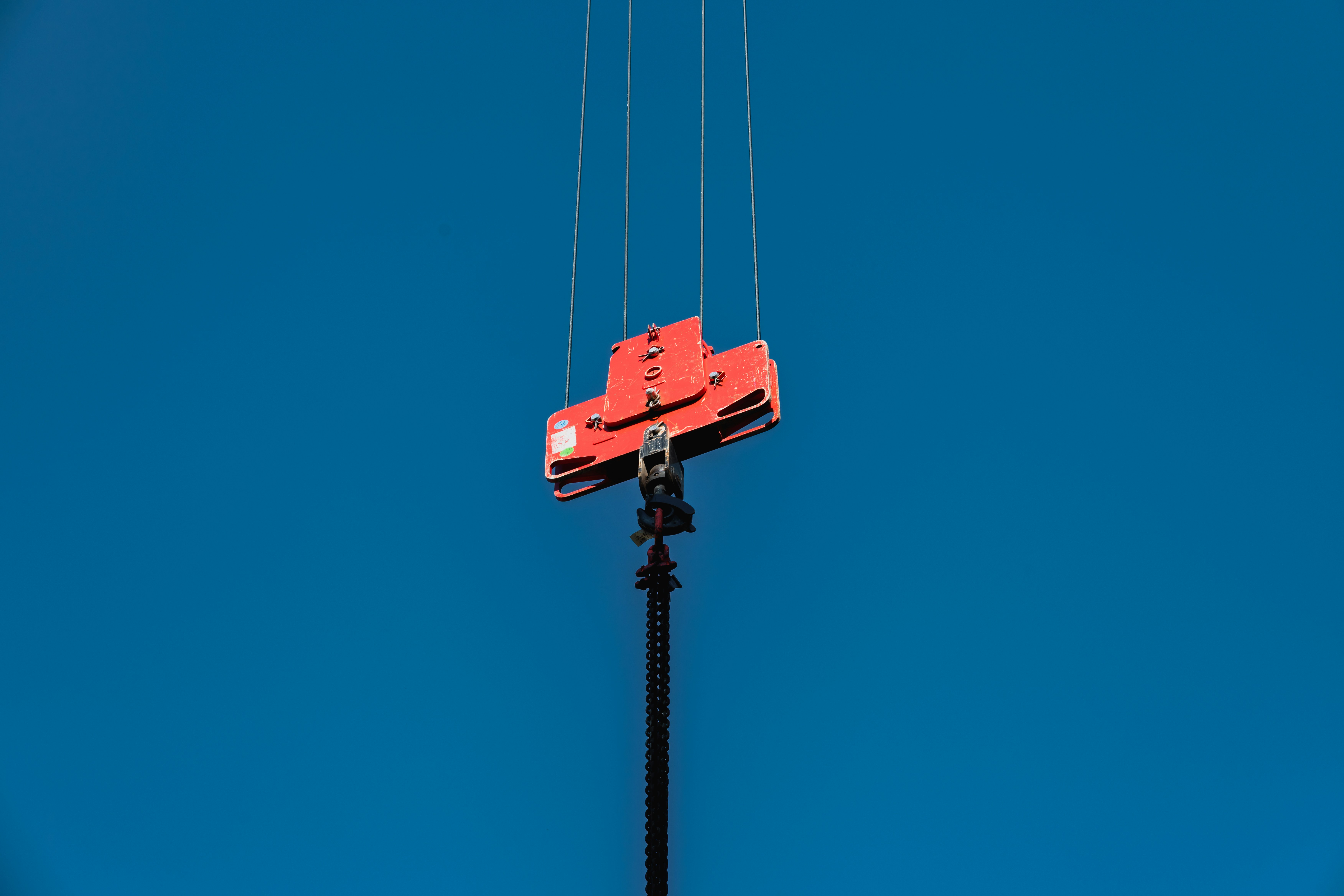Crane Latch: A Red Builder Raise Against a Clear Blue Sky