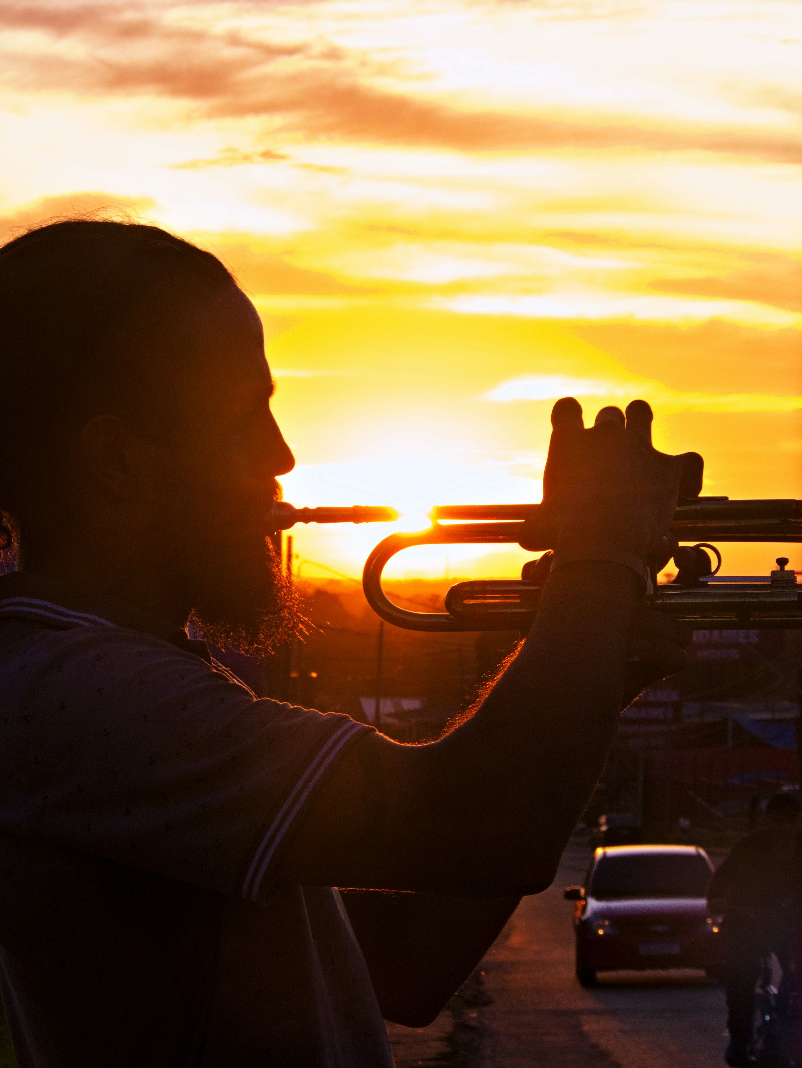Sunset Serenade: A Trumpet Player in silhouettes Against a Golden Skyline