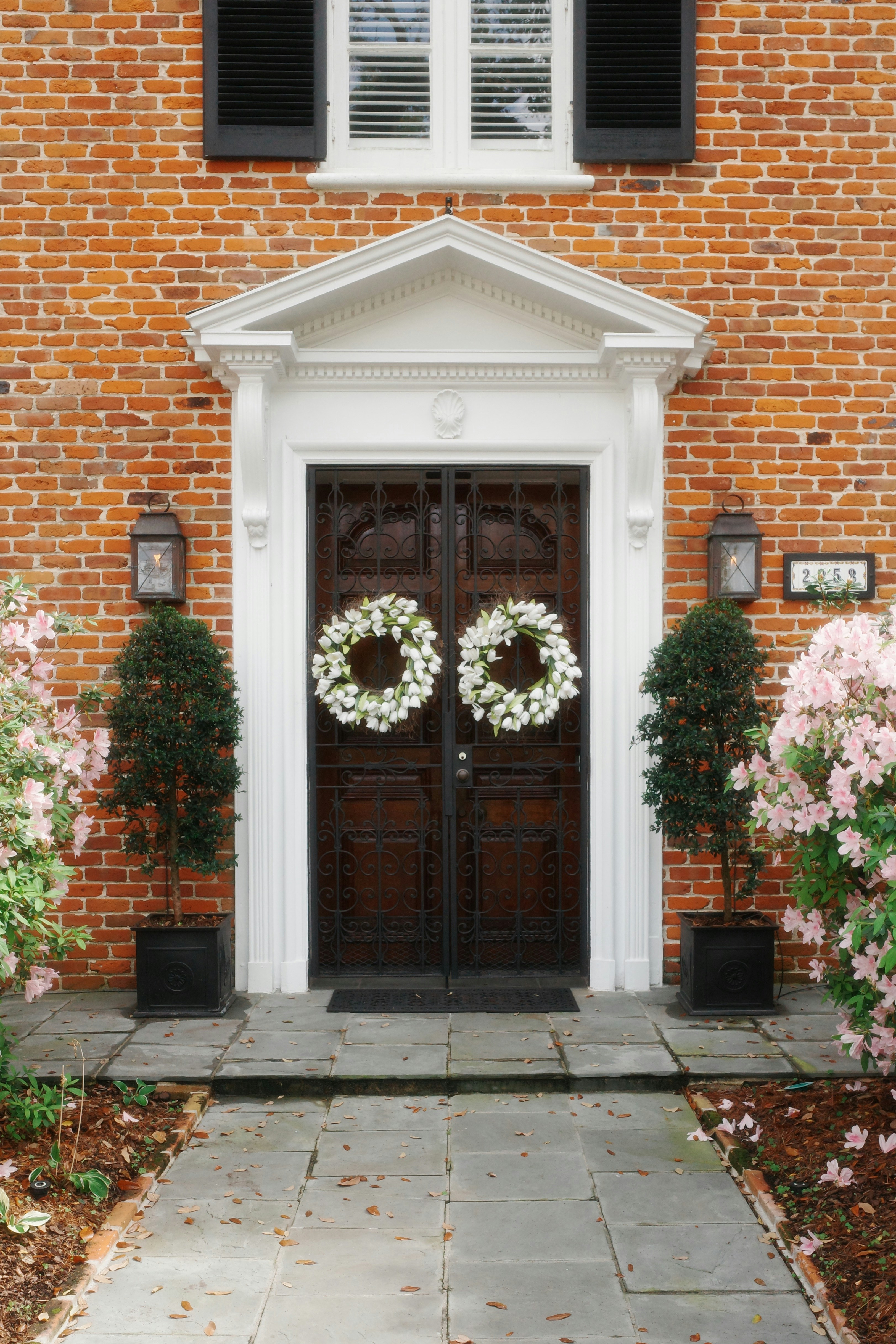 Wreaths on a Grand Wooden Door Fronted by White Trim
