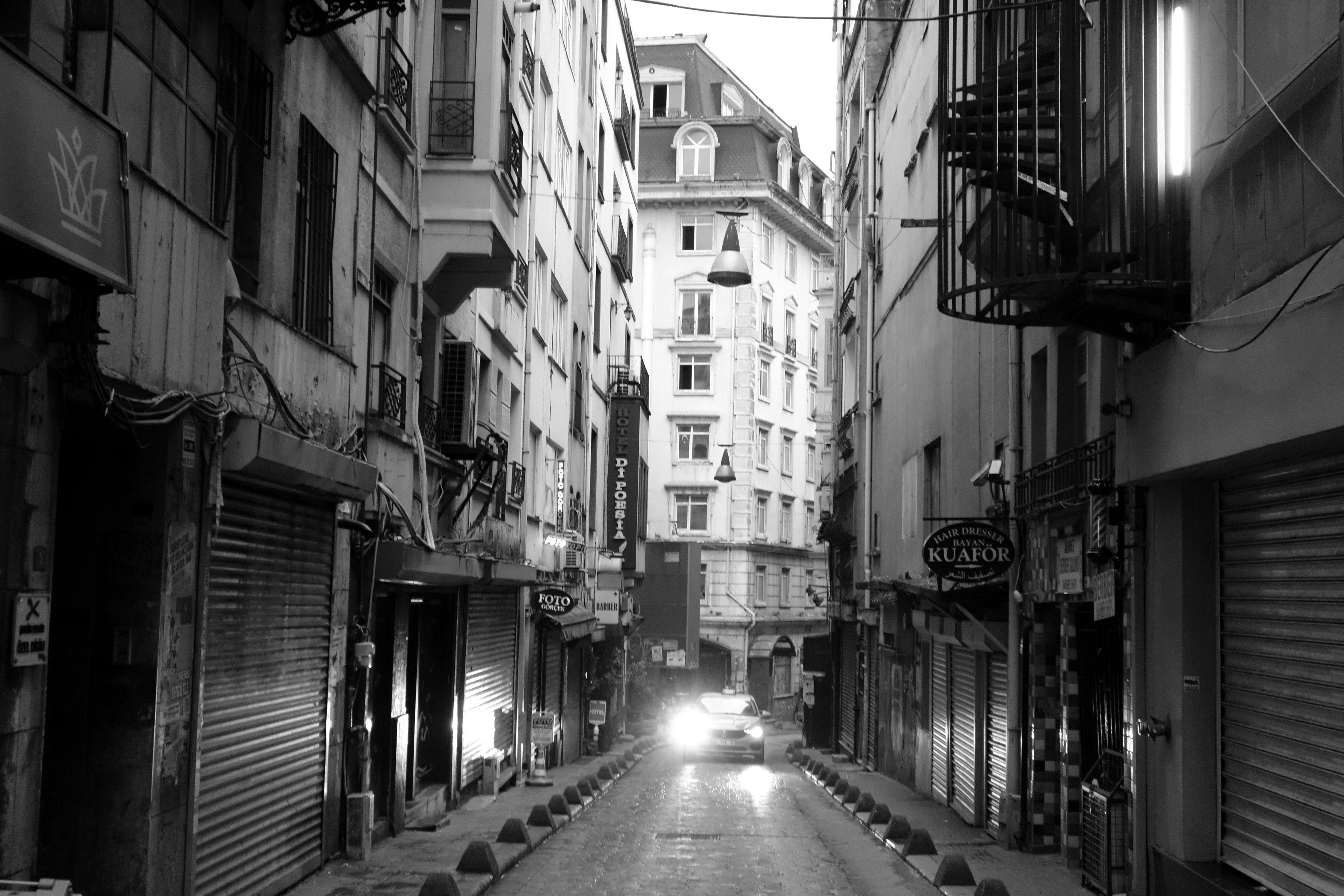 Night Street Convergence: A Narrow Alley Guides the Car's Glow