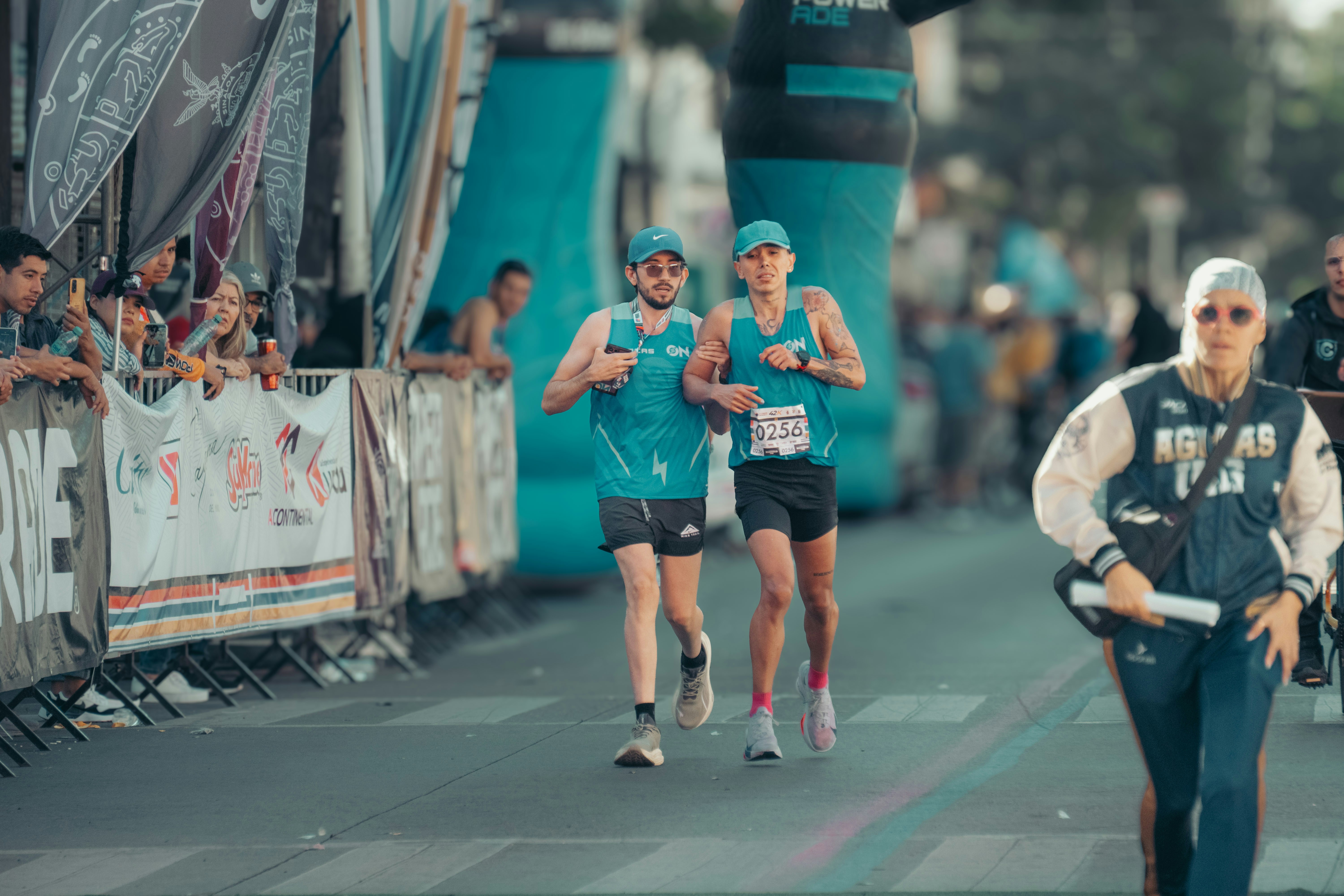 Couple in Blue Races Toward the Finish as a Support Crewer Guides the Lane