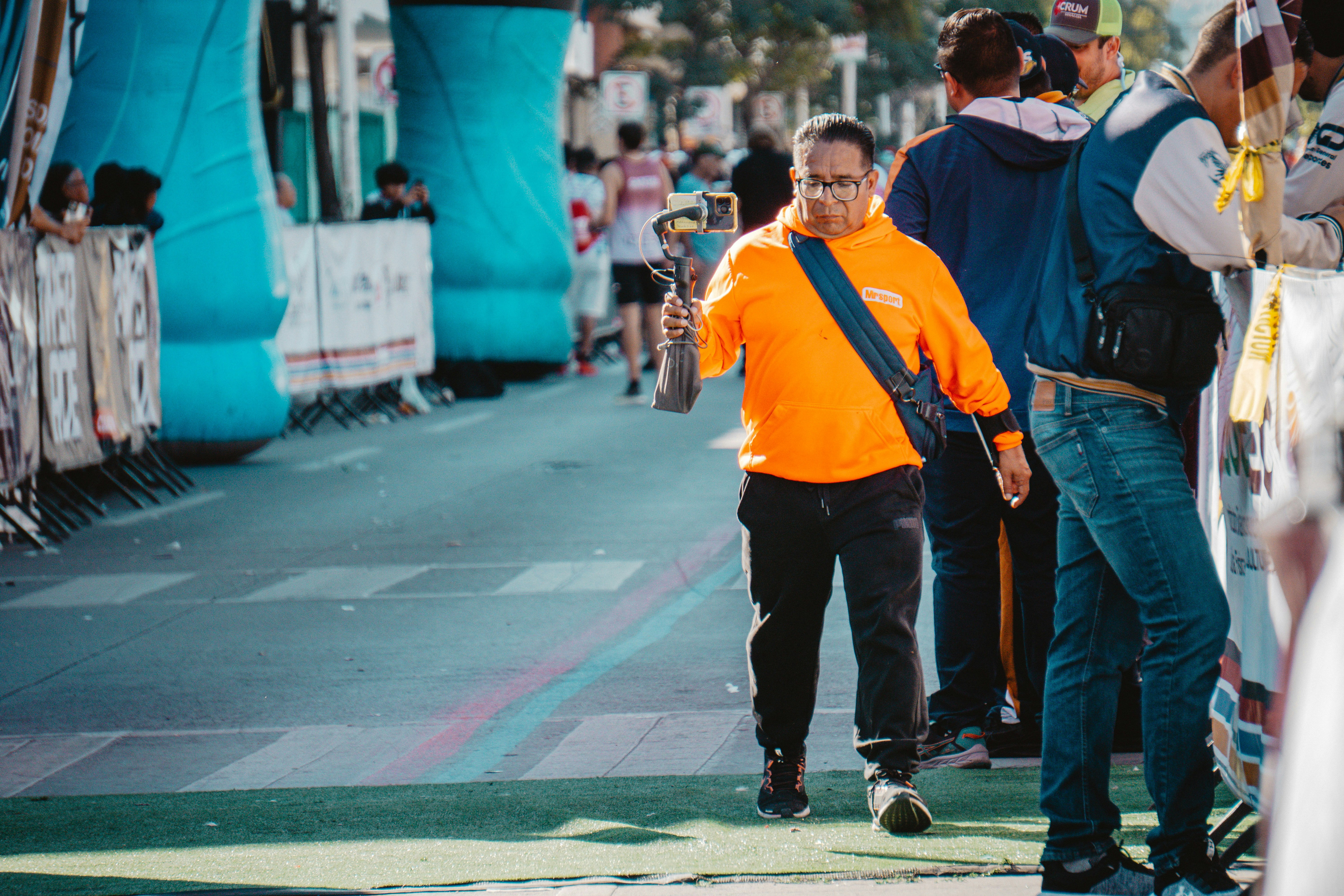 Orange-clad Official Captures a Moment at the Finish Line