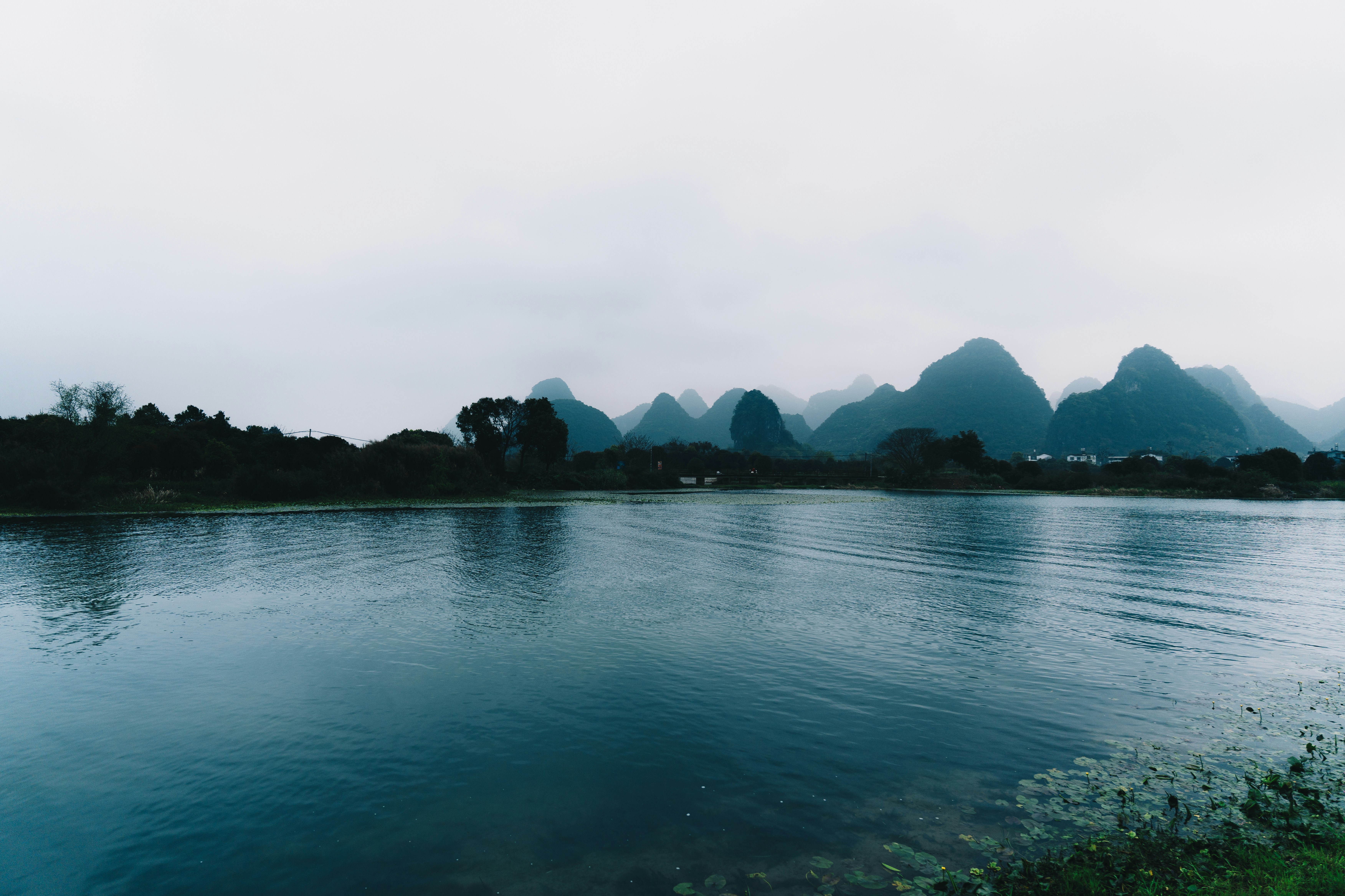 Misty Karst Ridge Across a Calm River