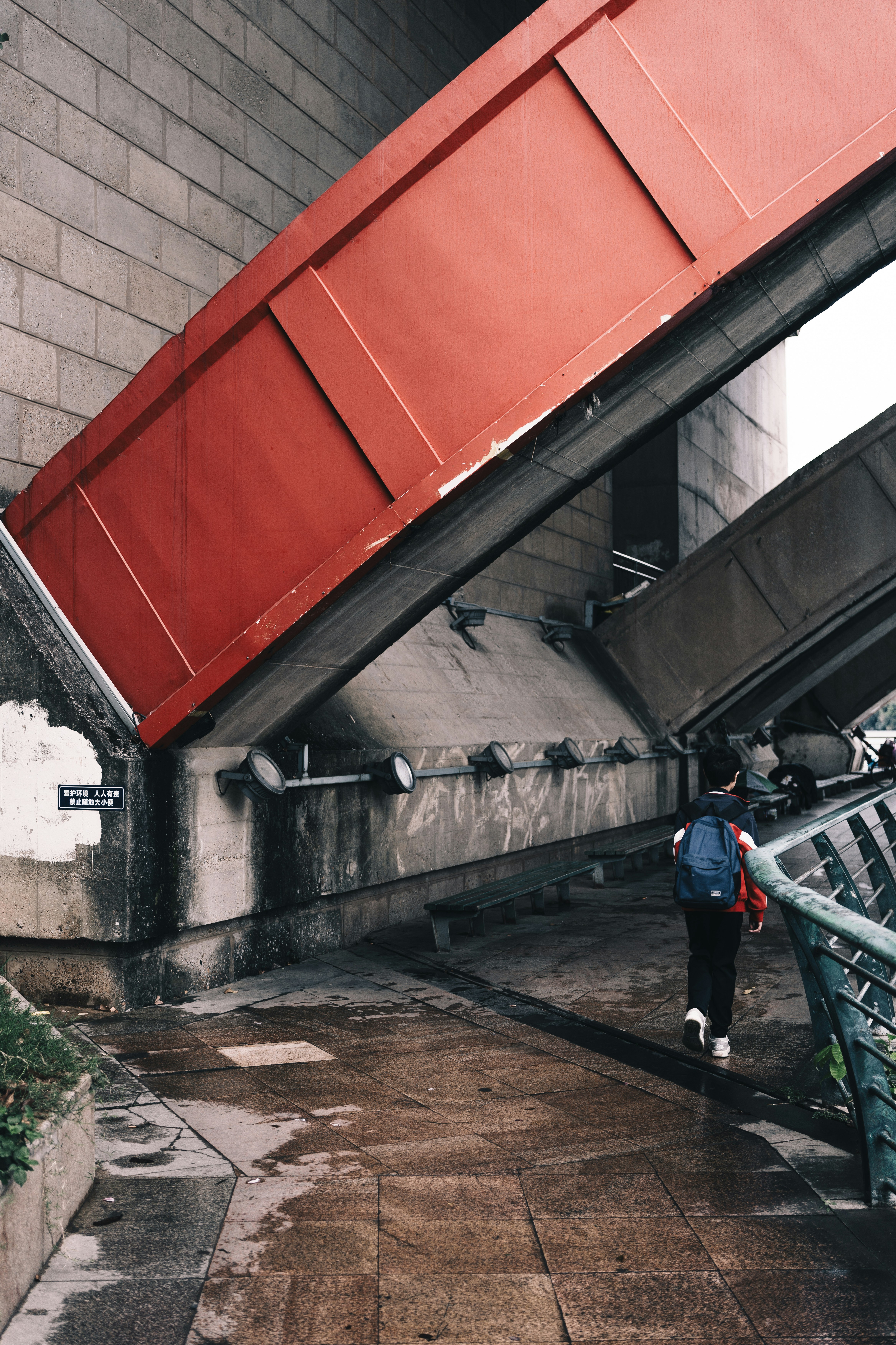 Red Ramp Overpass: A Lone Traveler Beneath Steel and Concrete