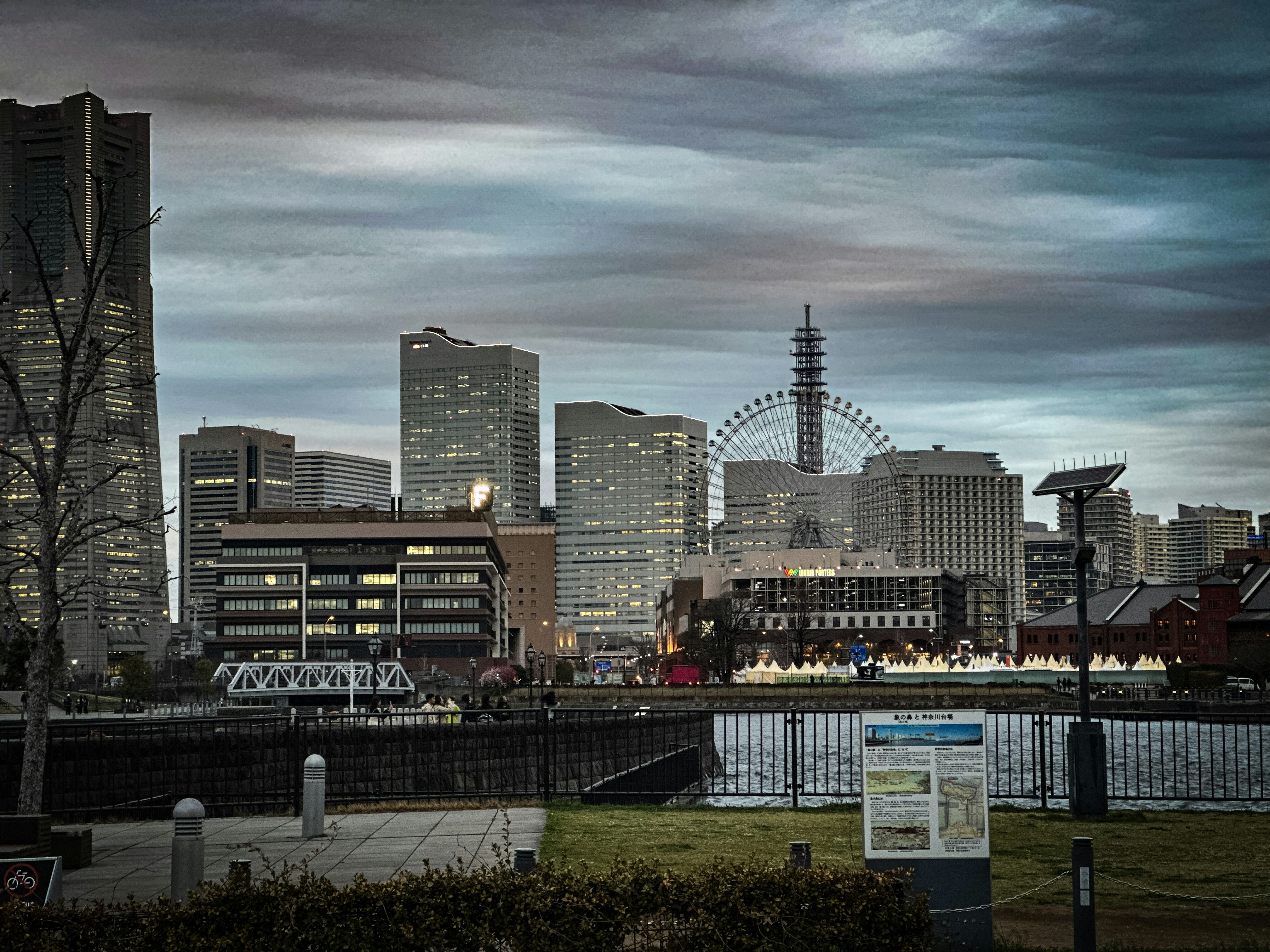 Urban Waterfront Mirage: Skyscrapers, Wheel, and Pier Lights