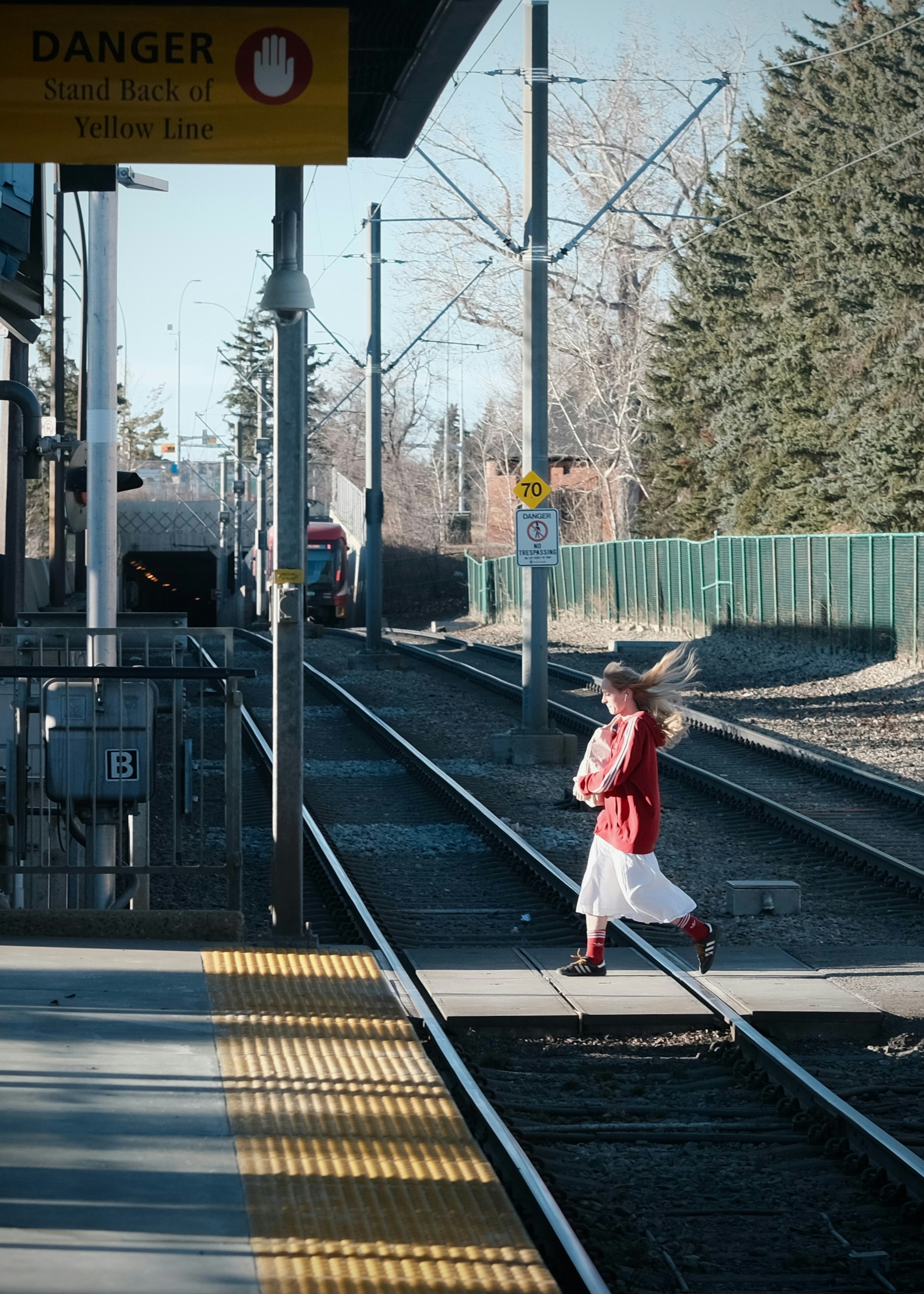 Red-Sweater Run to Safety on a Quiet Rail Platform