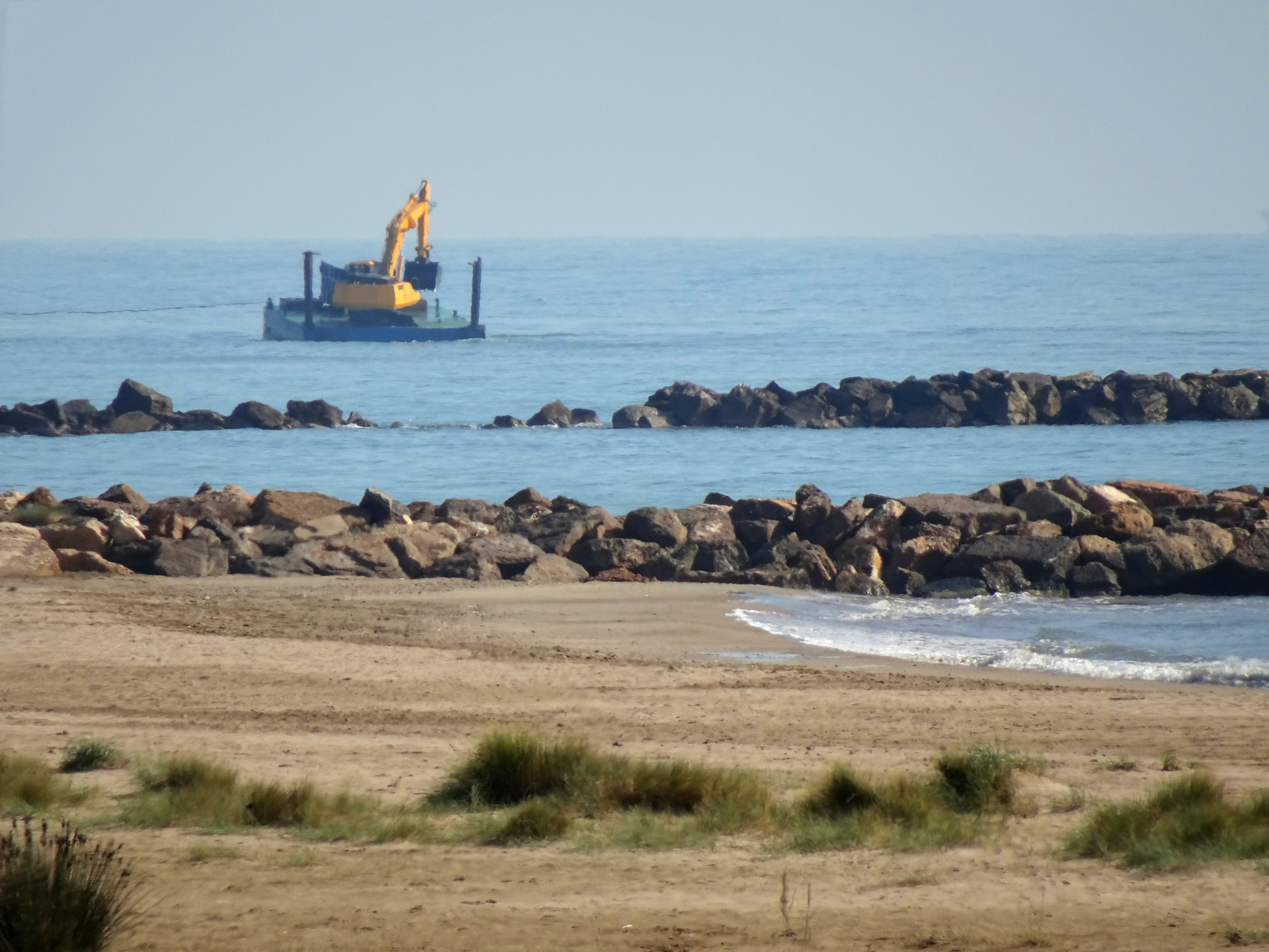 Harbor Workboat Anchored Beyond a Pebble Breakwater