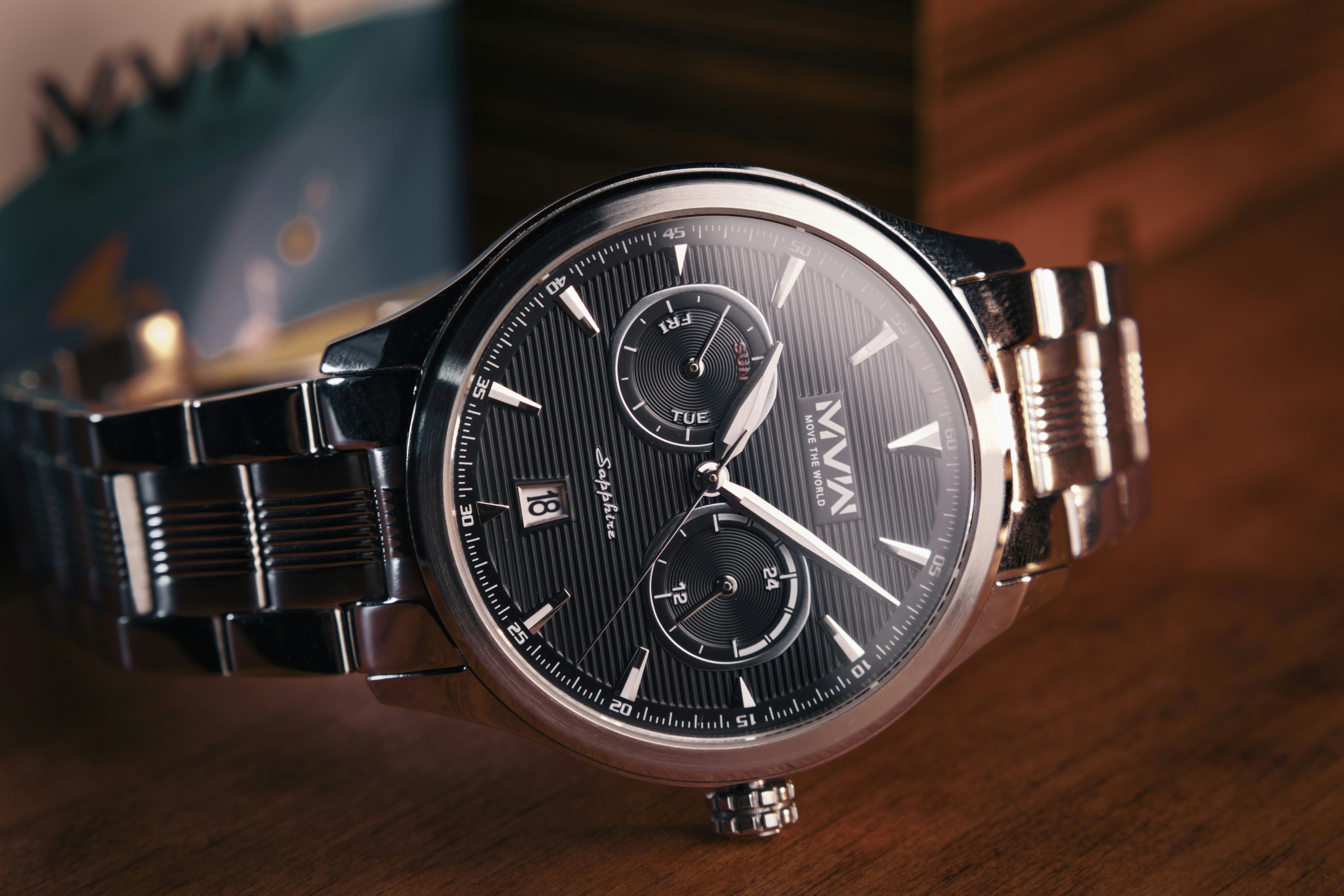 Starlit Chronograph: A Stainless Steel Wristwatch resting on a wooden surface