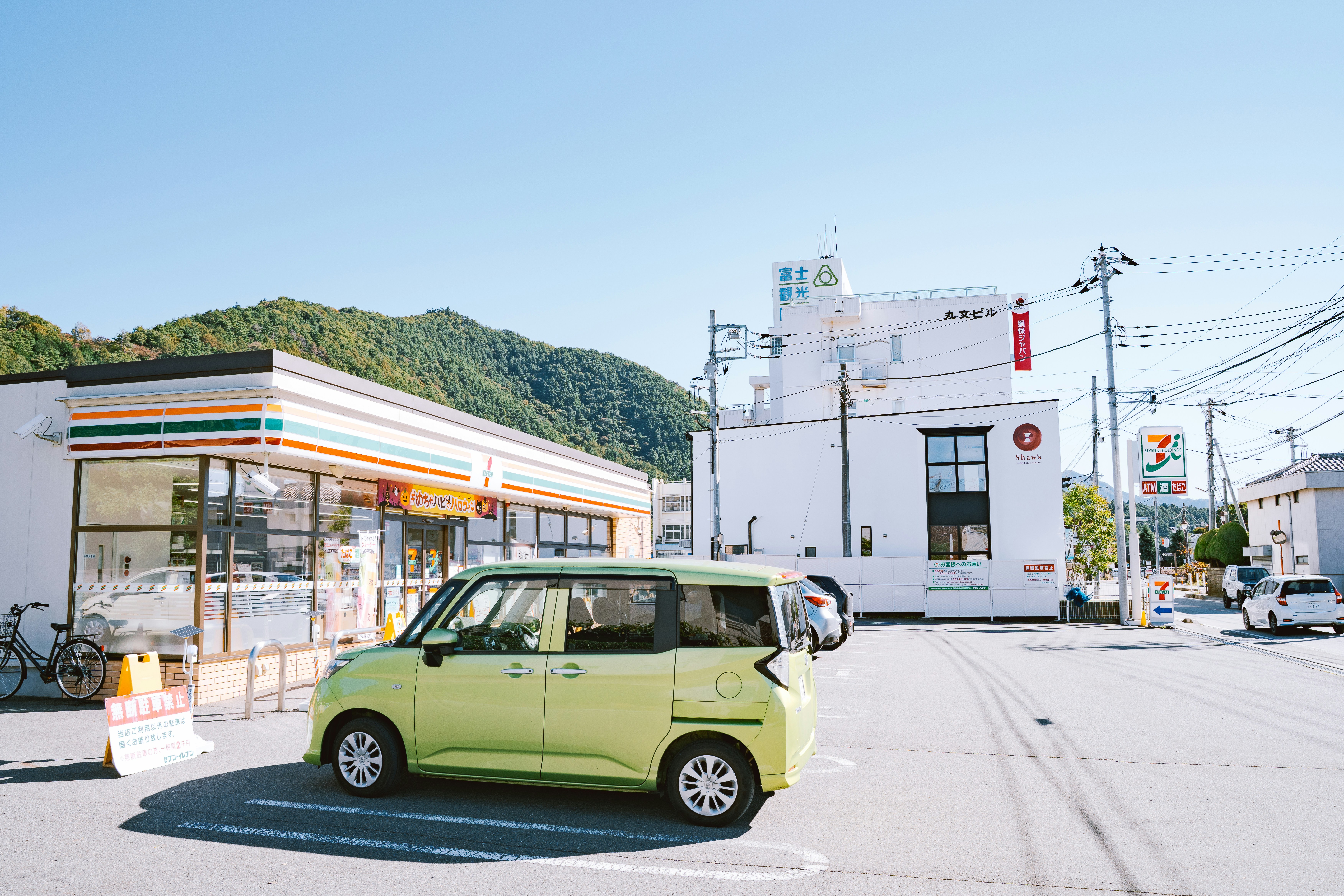 Lime taxi at a sunlit rural convenience storefront