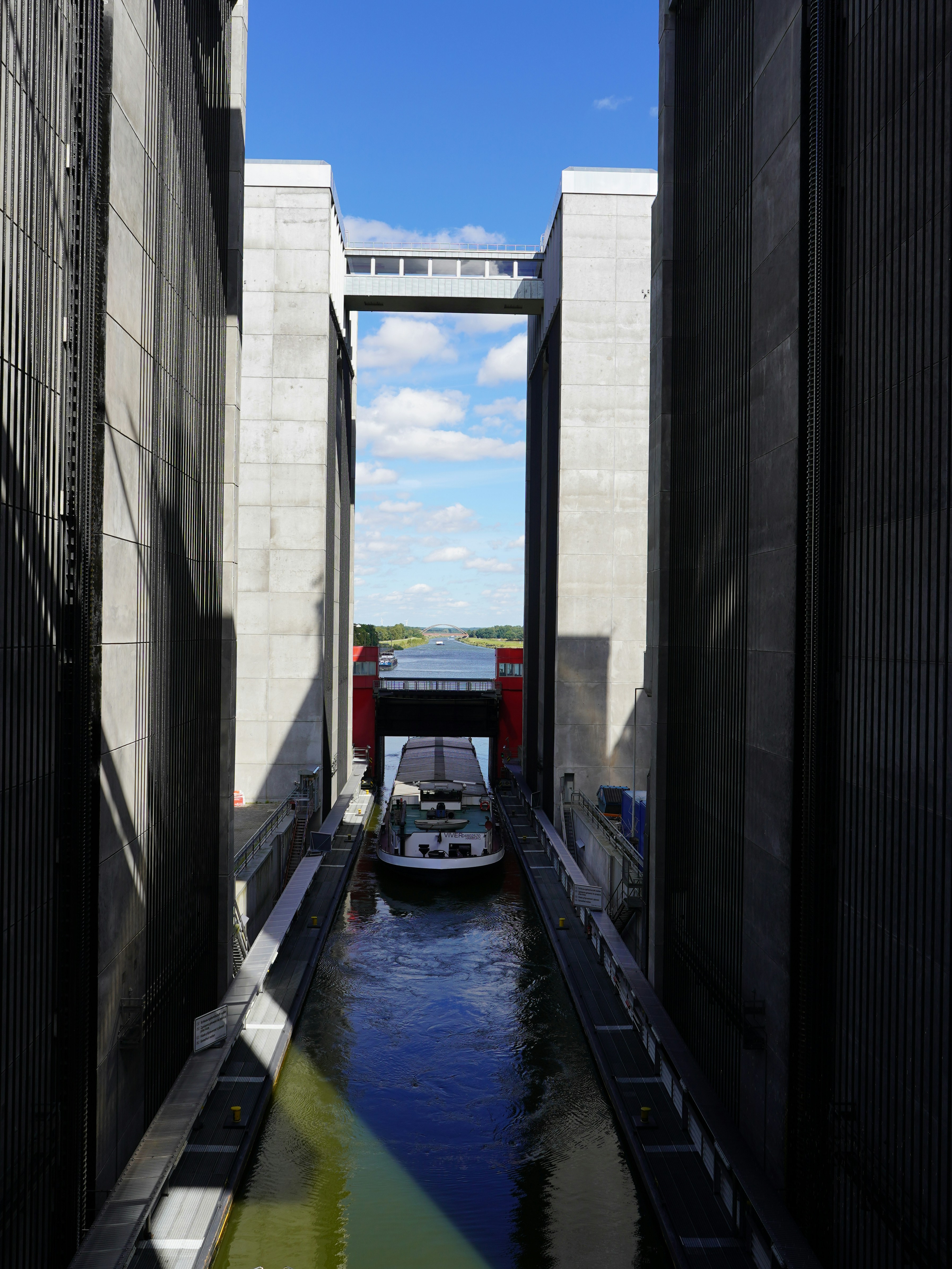 Lock Gate Vessel: Boat Emerging Through a Narrow Waterway Between Tall Concrete Walls
