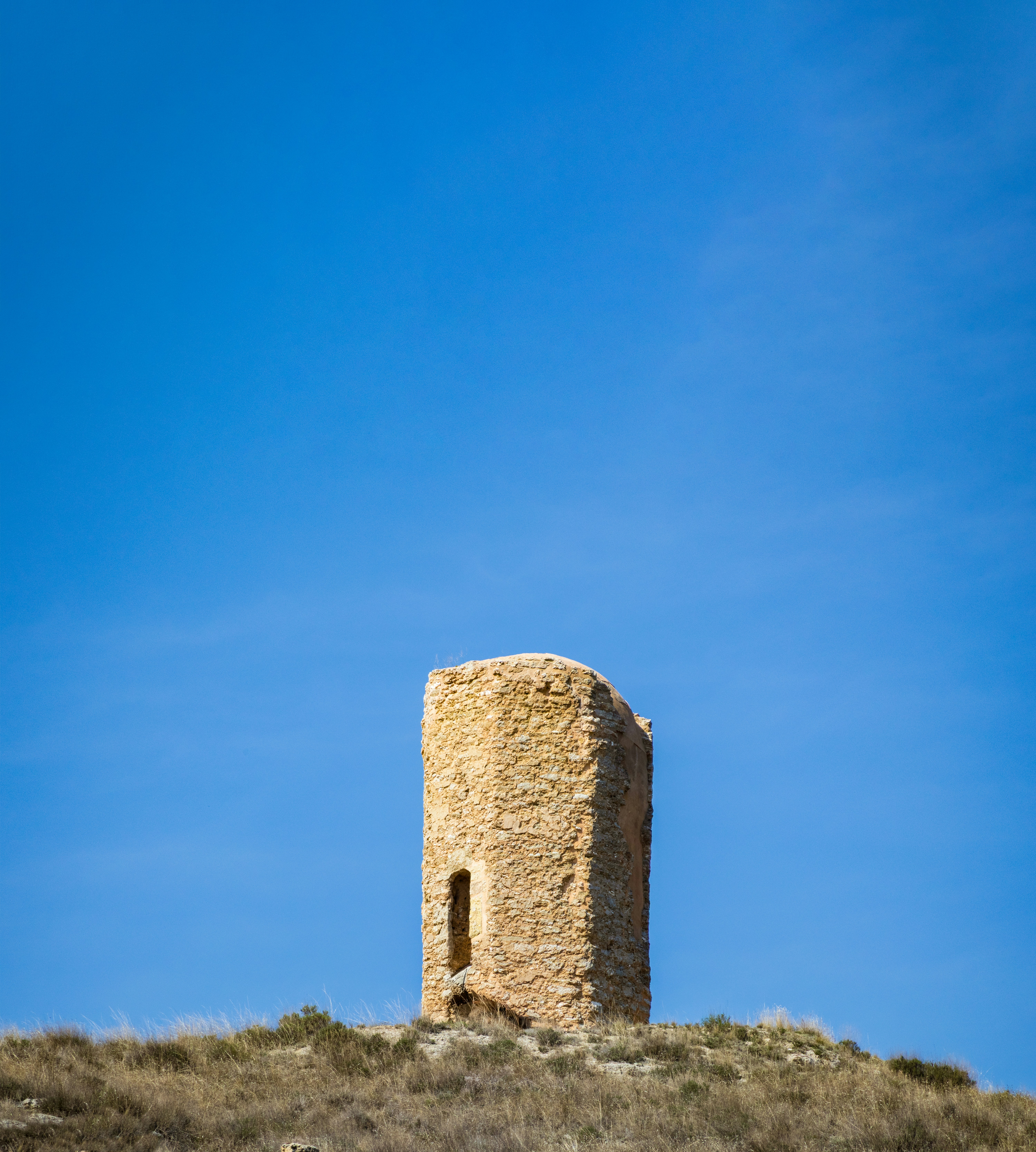 Stone Sentinel on a Gentle Slope under a Wide Blue Sky
