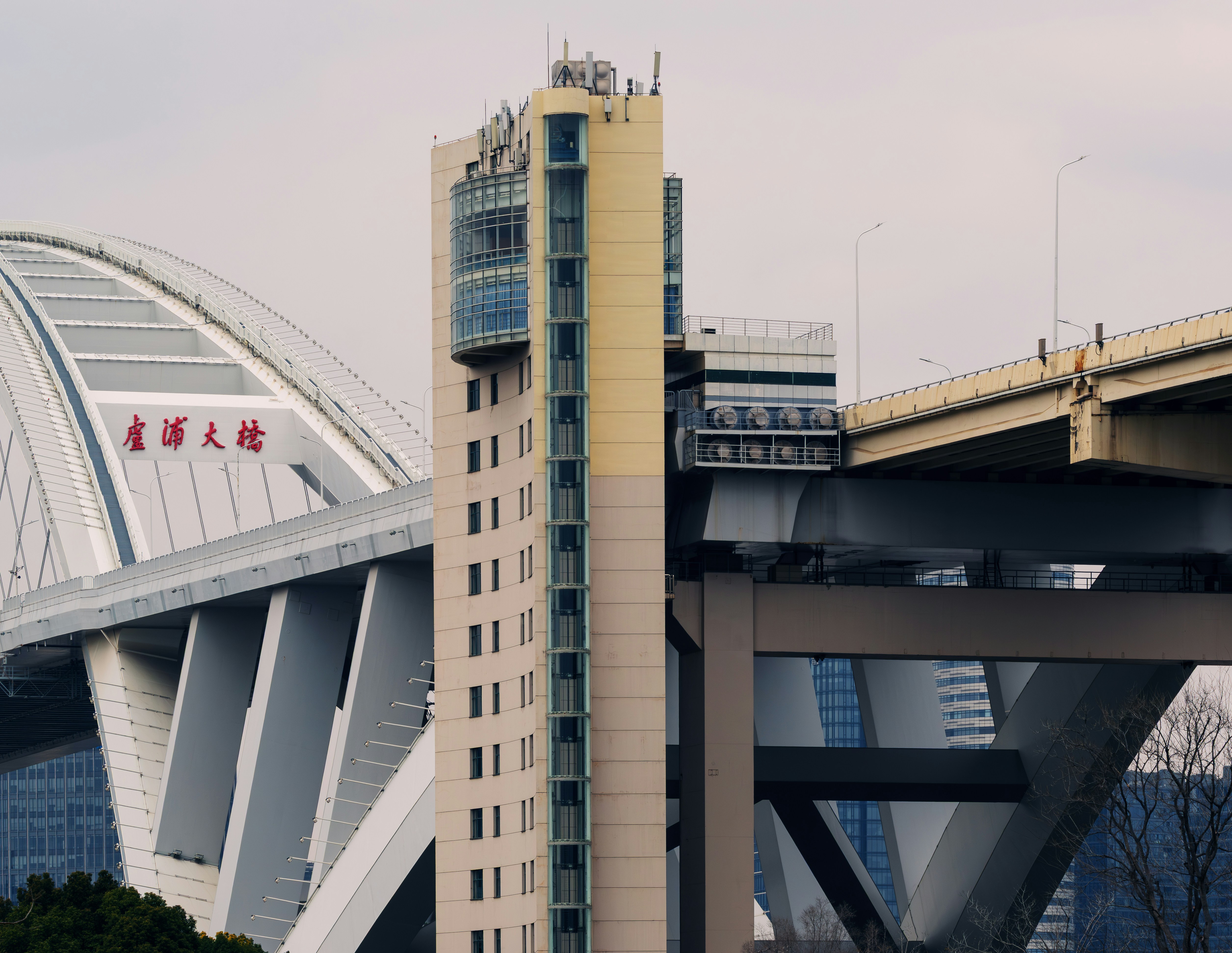 Vertical Elevator Tower Amidst a Modern Bridge Complex