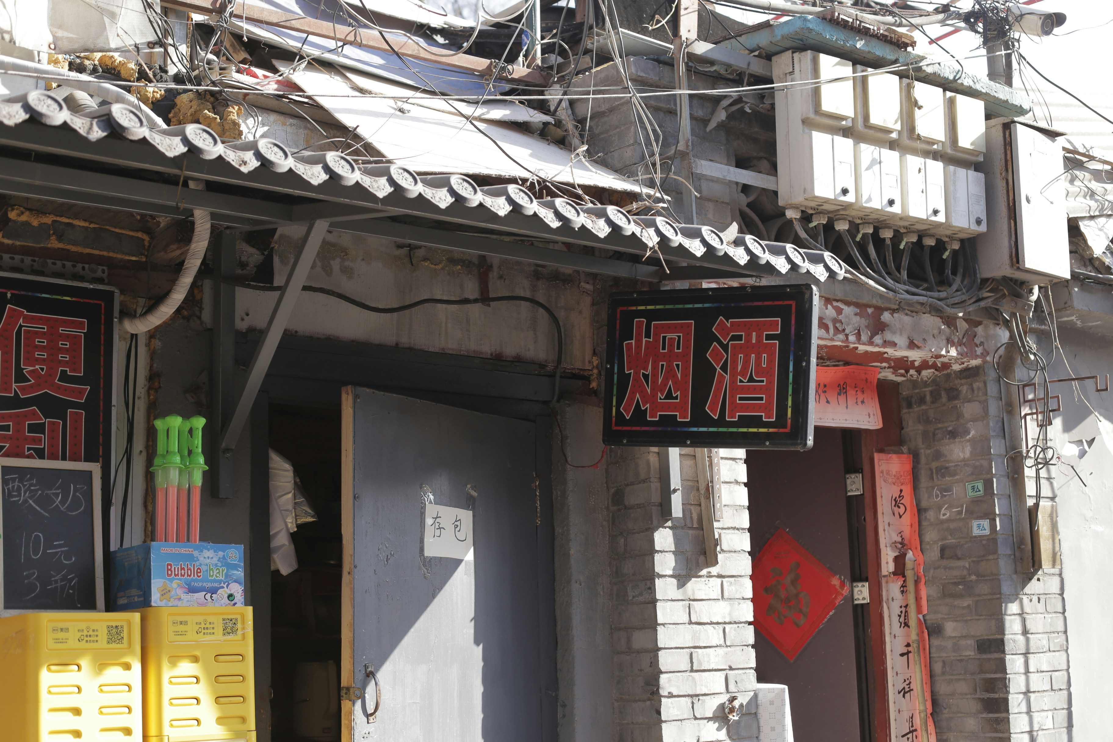 Old storefronts and red signage under a tangle of wires