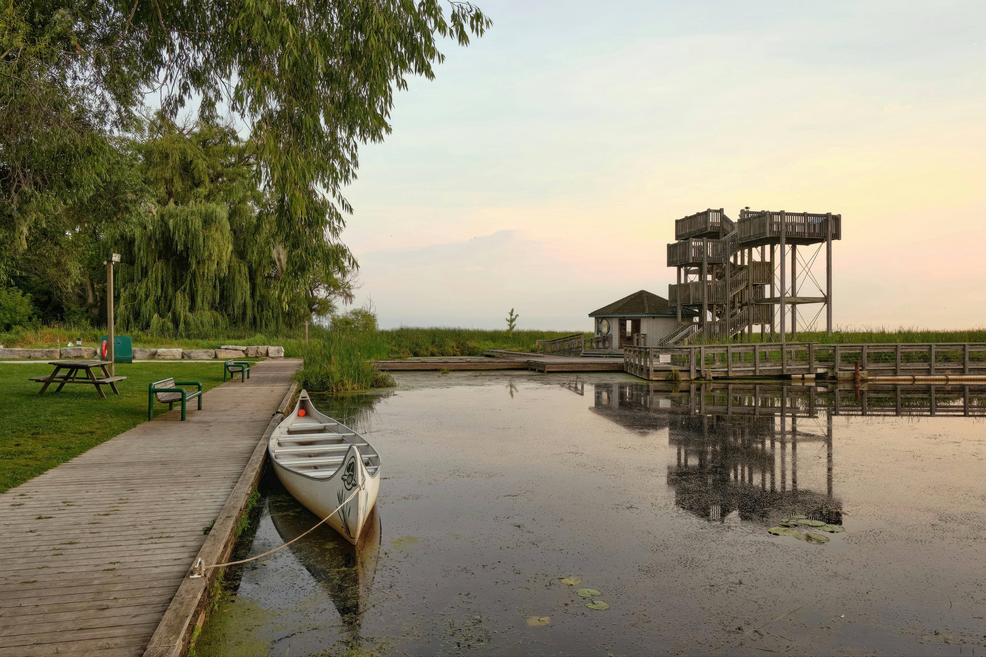 Quiet Riverside: A Canoe Beckons by the Docks at Dusk