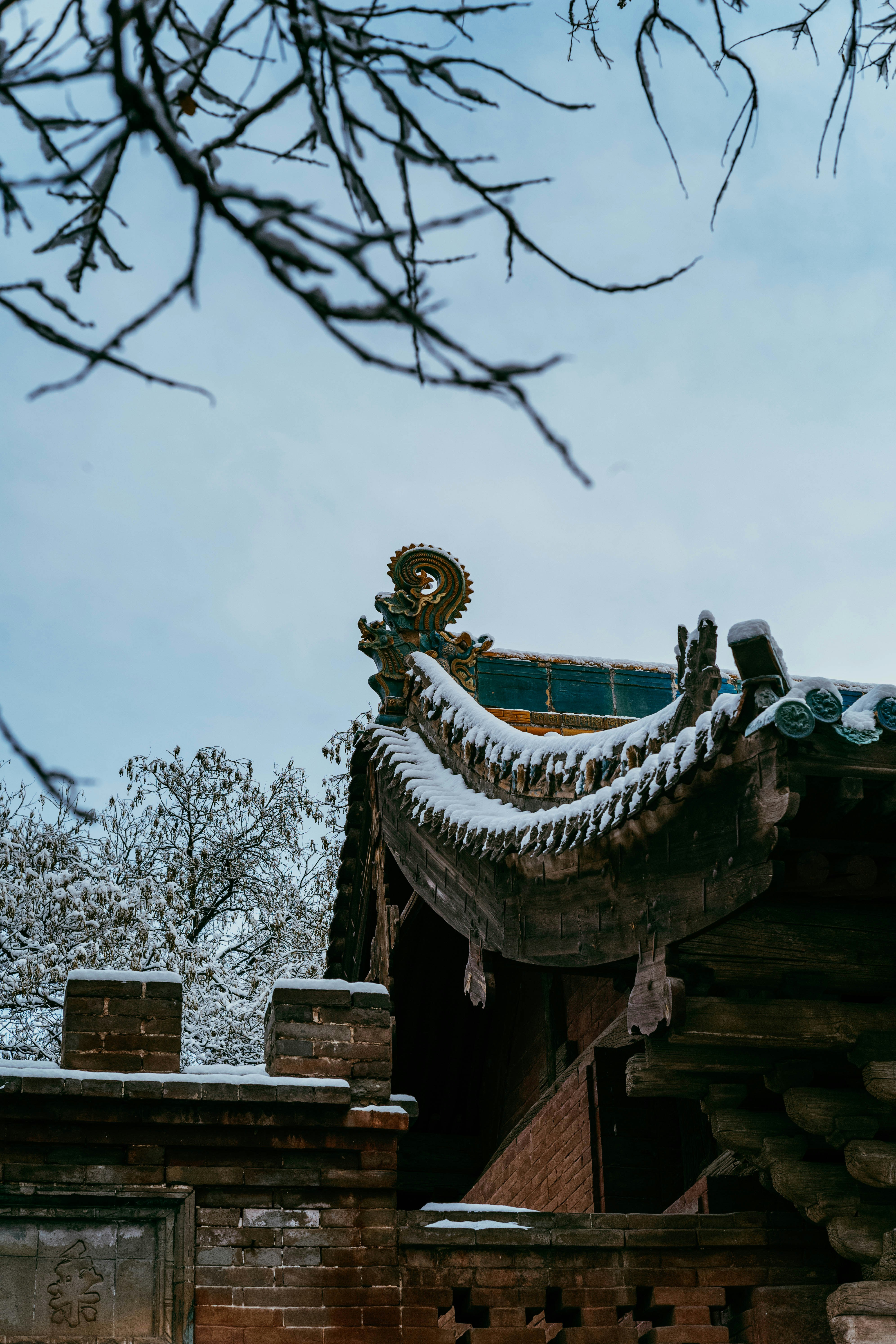 Snow-Capped Roofline: Ornate Corner of a Historic East Asian Pavilion