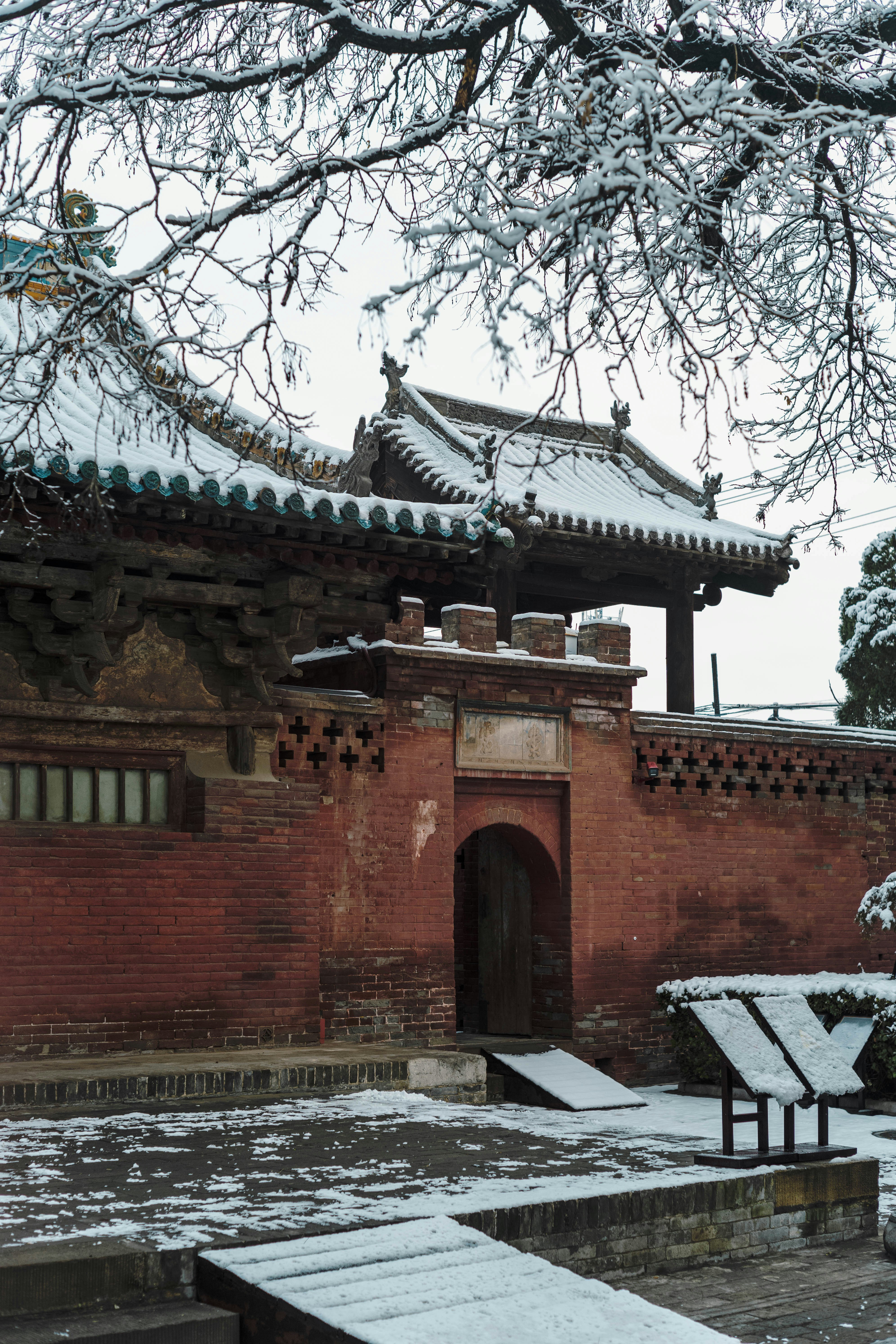 Snow-kissed Gate: A Quiet Red Brick Courtyard Under Winter Branches
