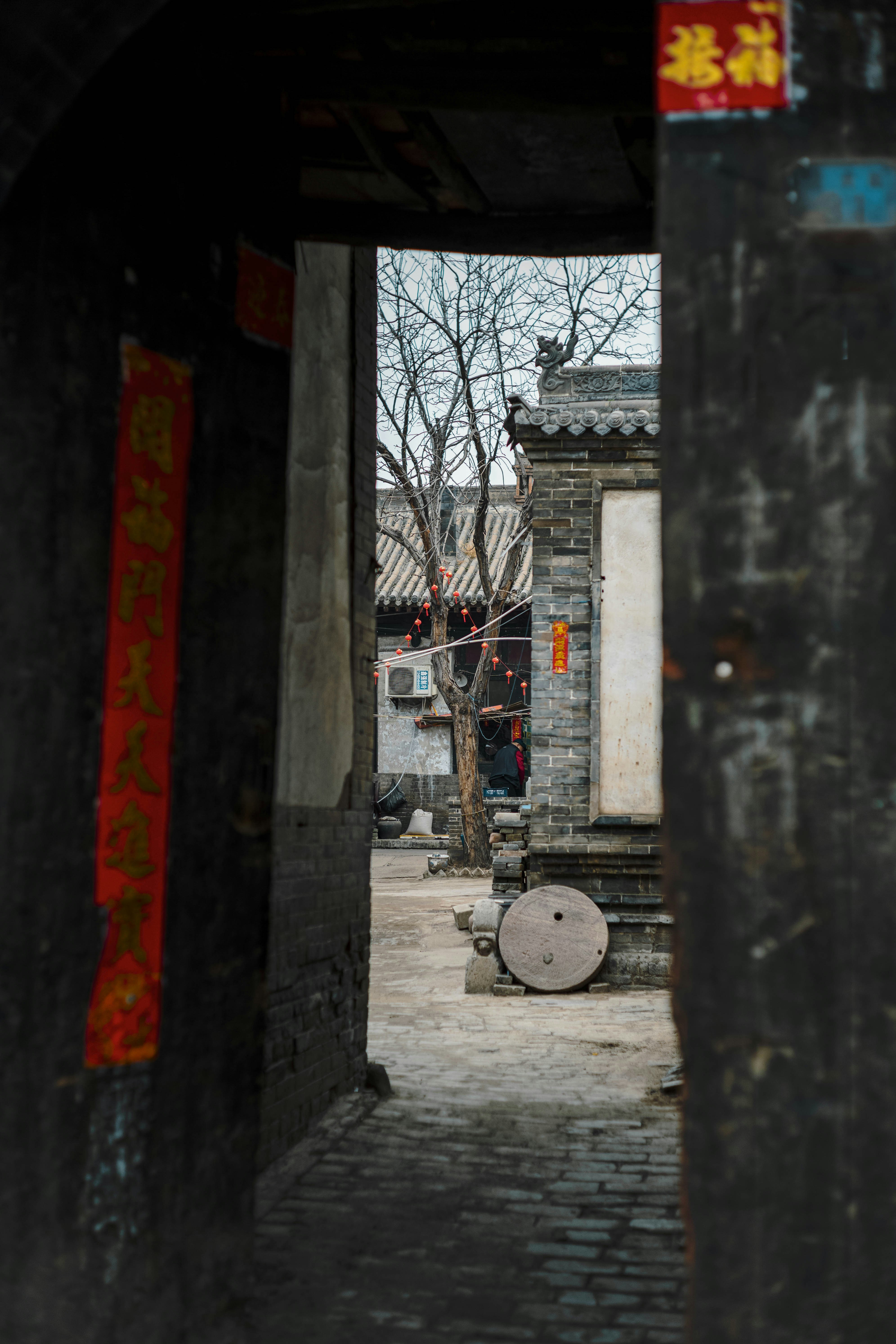 Through the Gate: A Quiet Alley of Red Couplets and Weathered Stone
