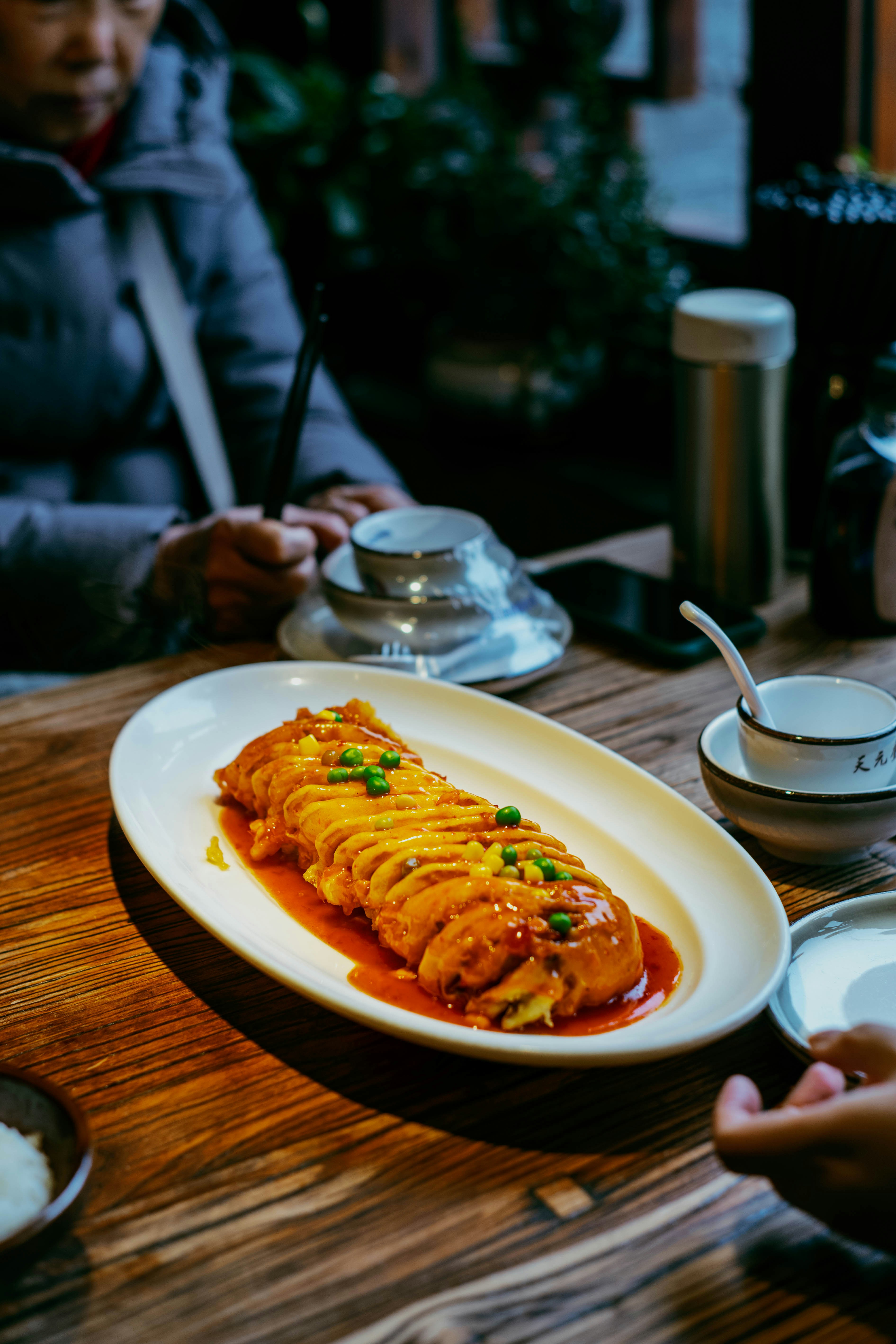 Sliced perfection: lacquered duck over a glossy plate in a cozy street-side meal