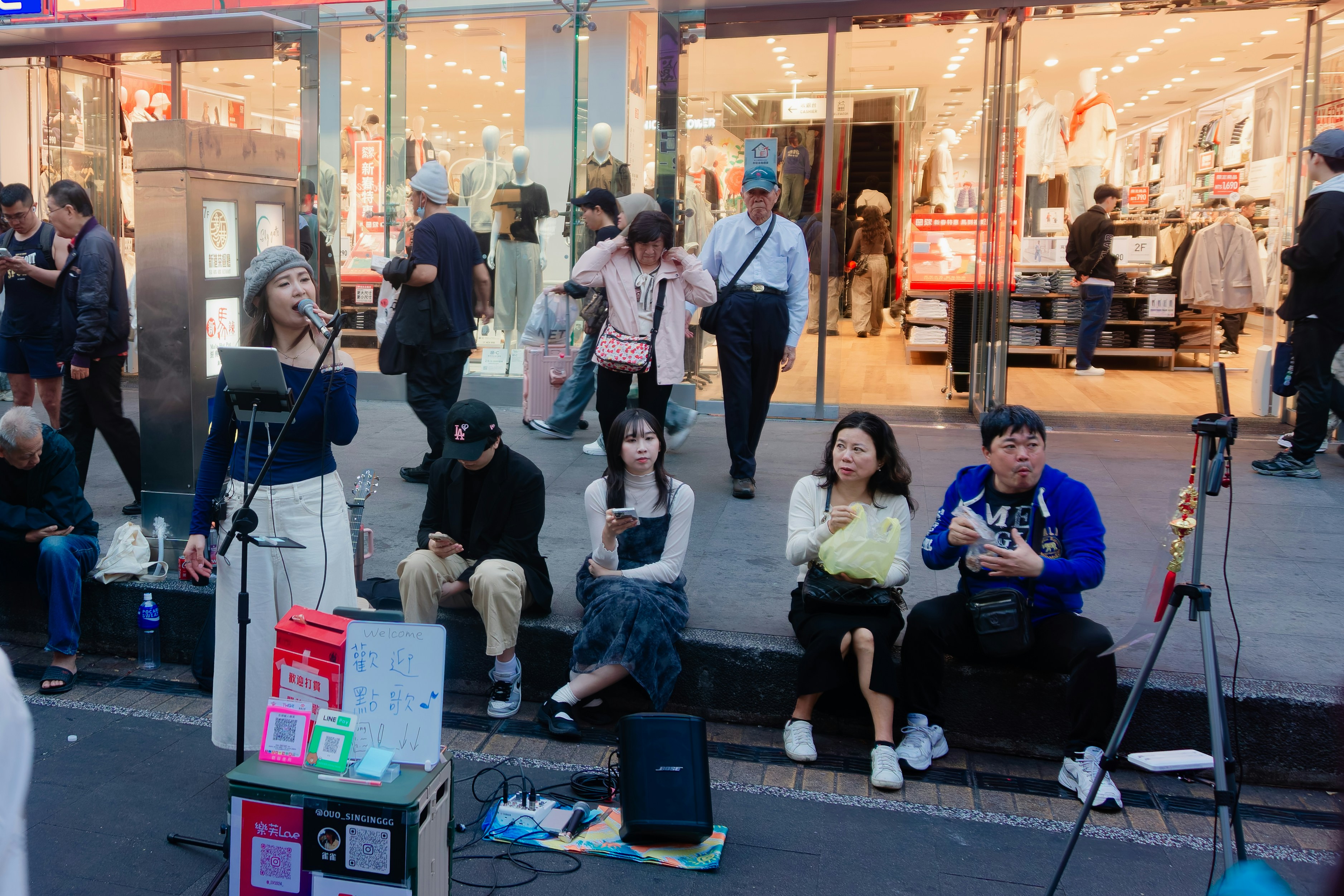 Street corner basso: a busker quartet beneath shopfront lights