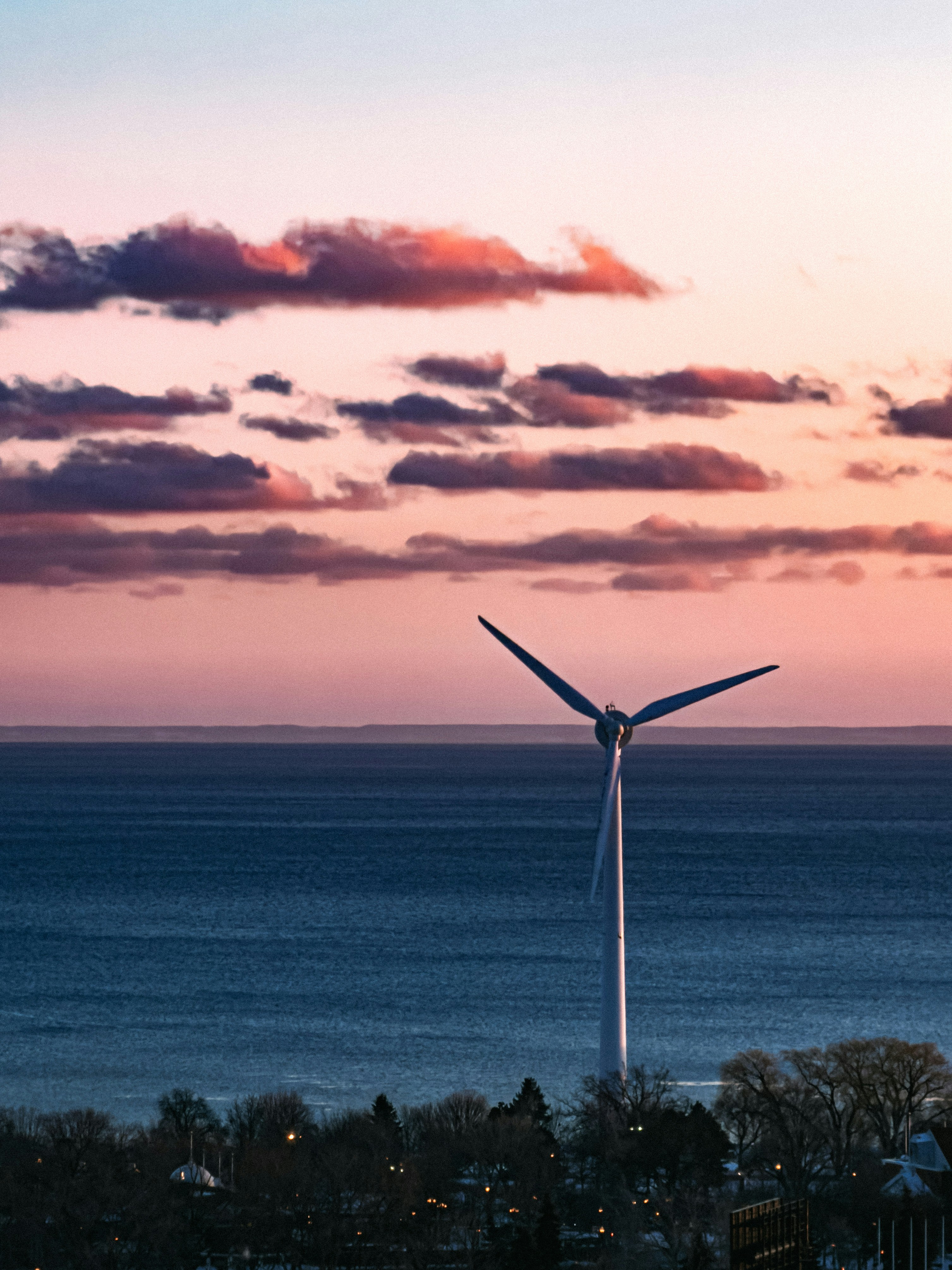 Wind Turbine at Dusk Over Calm Sea