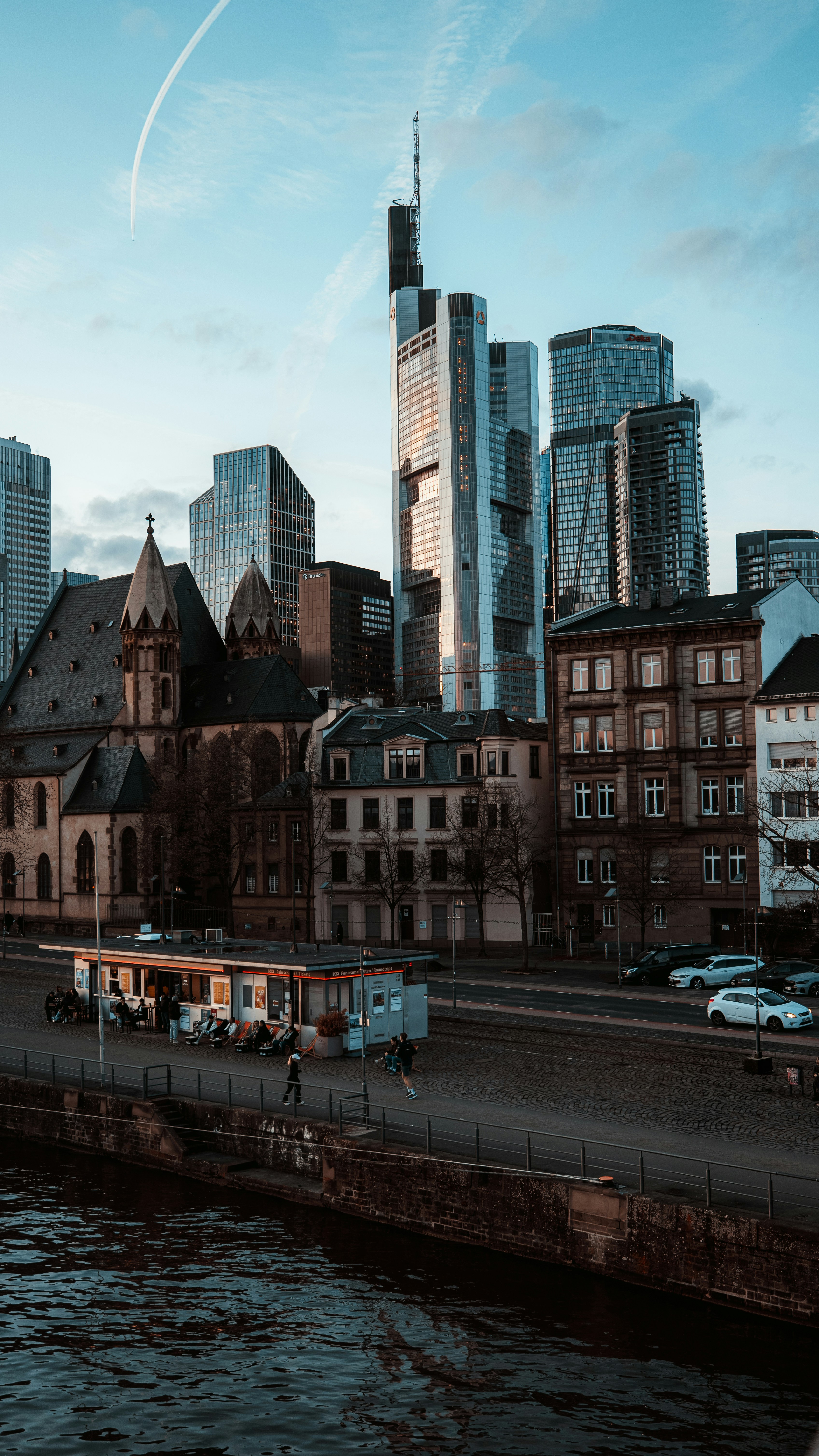 City Silhouette by the River: Modern Towers Over Historic Roofs