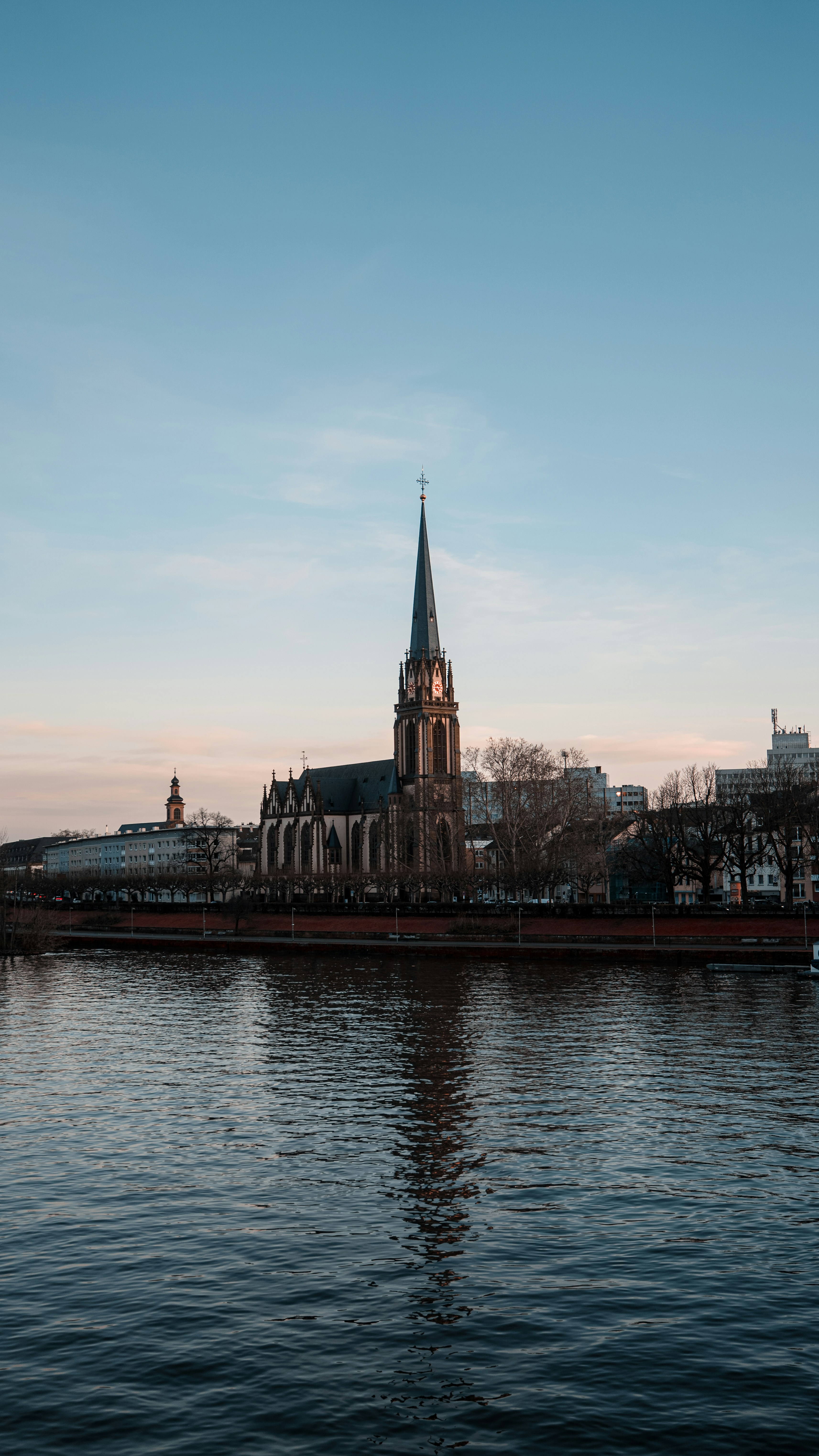 Spire Over the River: A Church Silhouette at Dusk