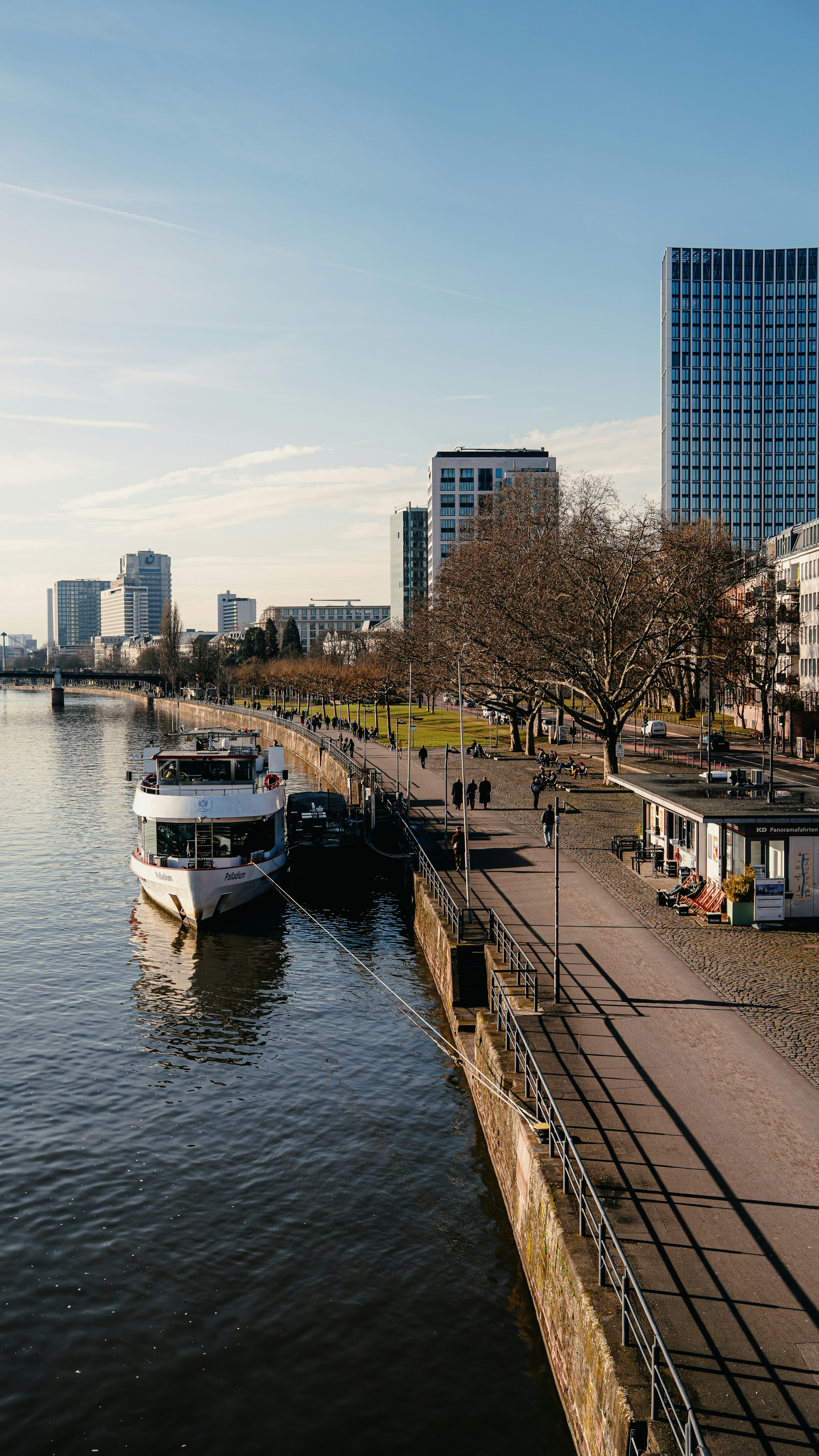Riverside Passage: A Sunlit Waterfront with Modern Towers