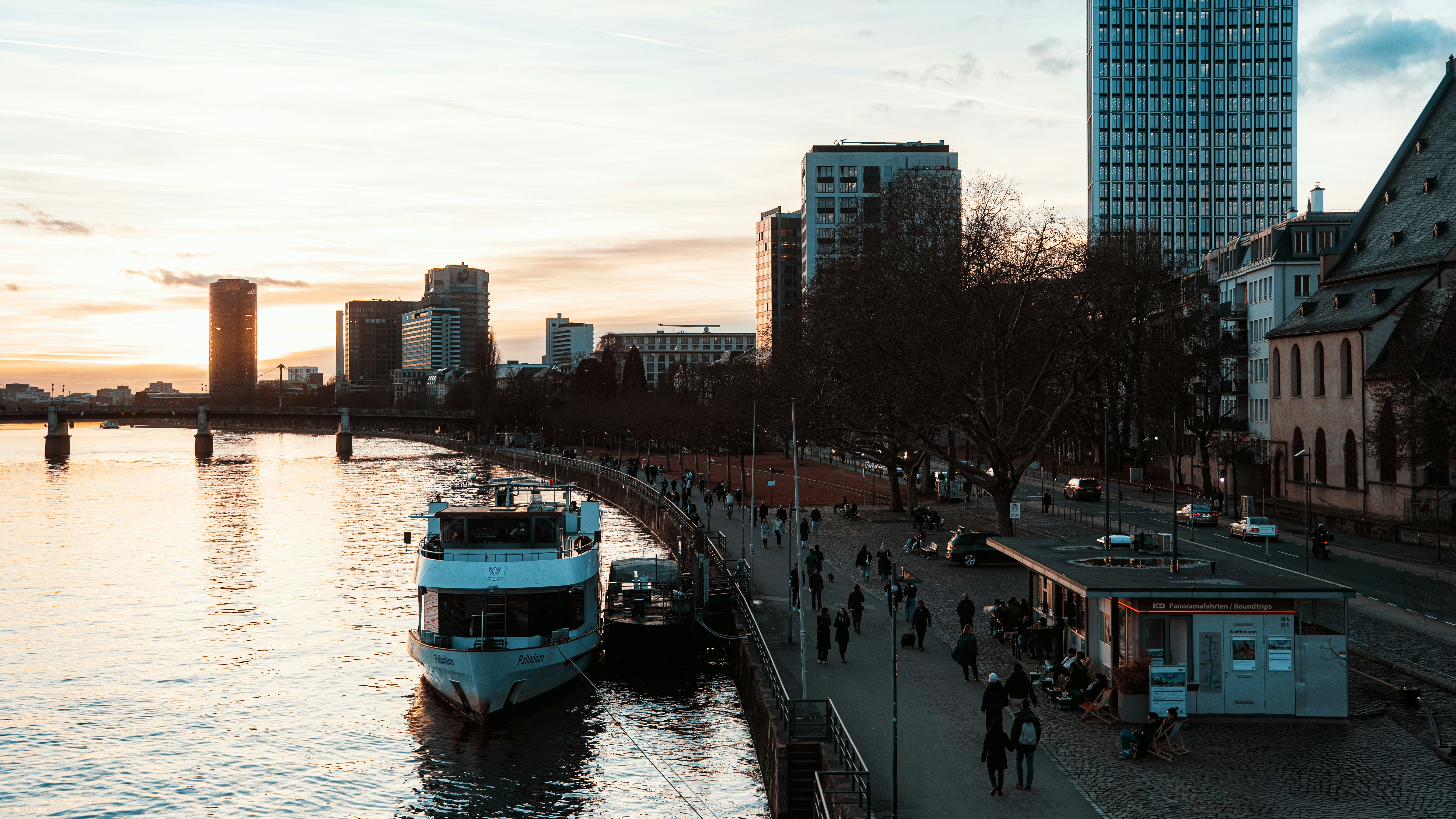Sunset along the Riverfront: A Quiet City Scene with a Docked Boat