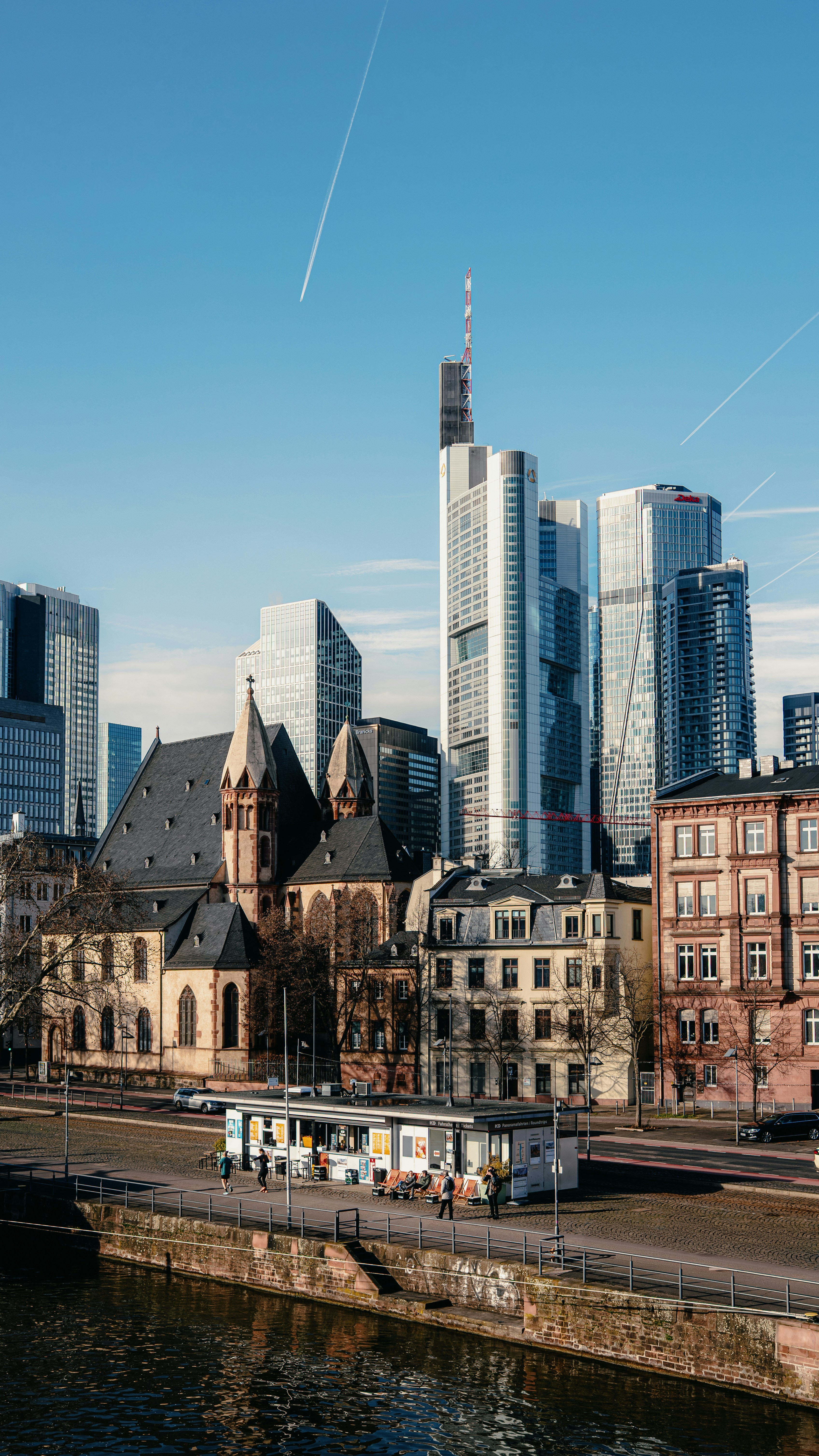 Modern skyscrapers and historic church in a city.