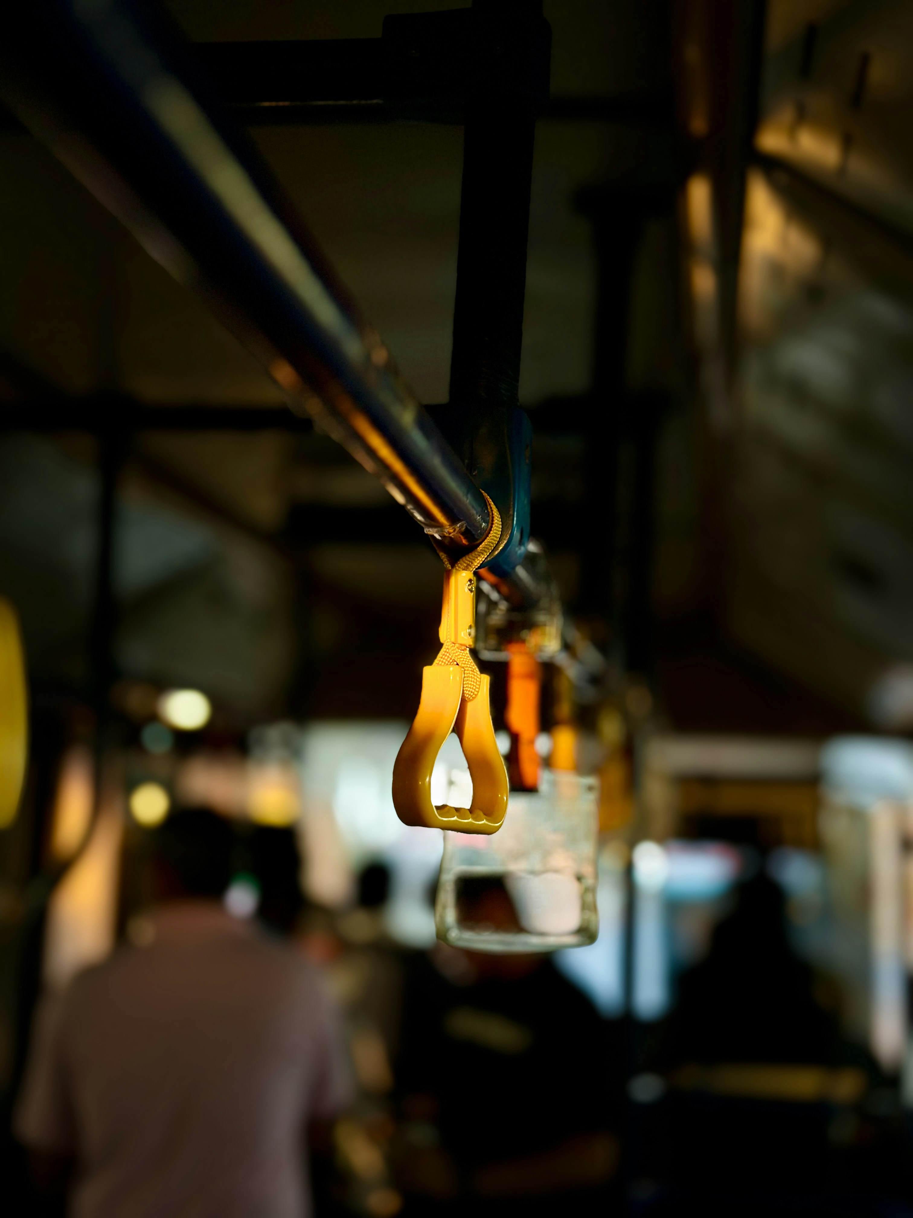 Yellow Handrail Grippers: A Line of Limbs in a Dim Bus Interior