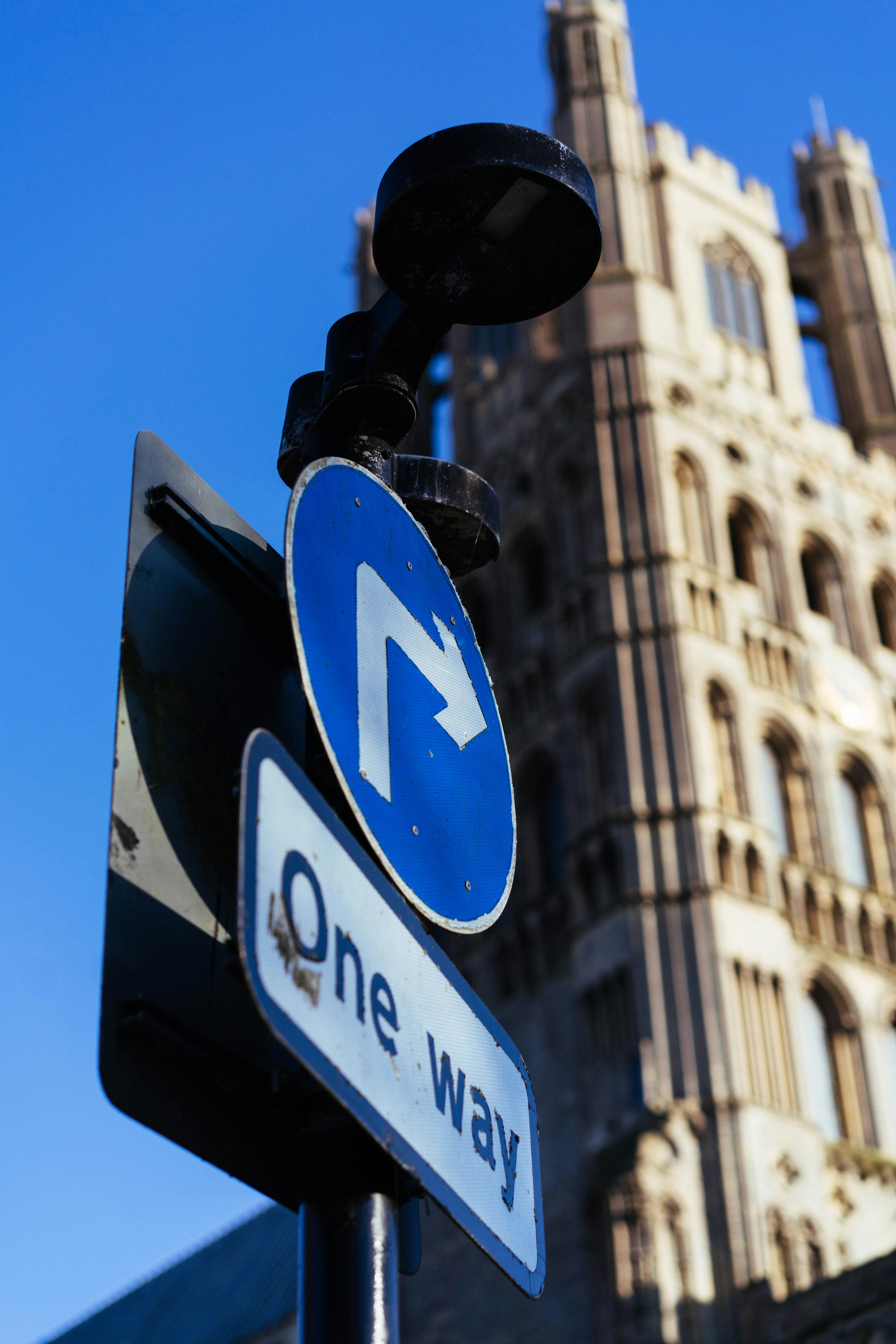 Blue Turn Sign over a Gothic Cityscape