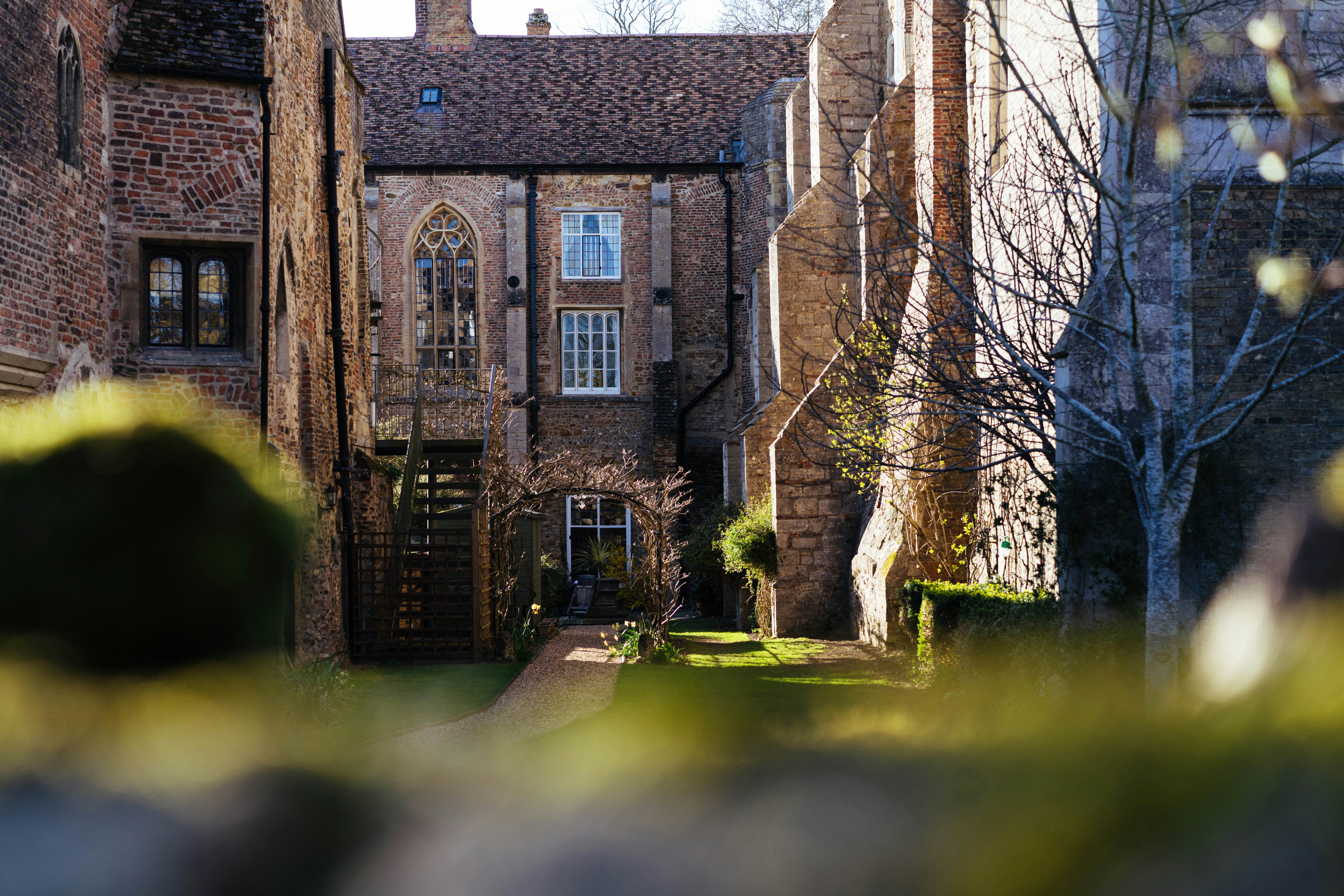 Inner Courtyard in Focus: Brick Architecture Framed by Blooming Foliage