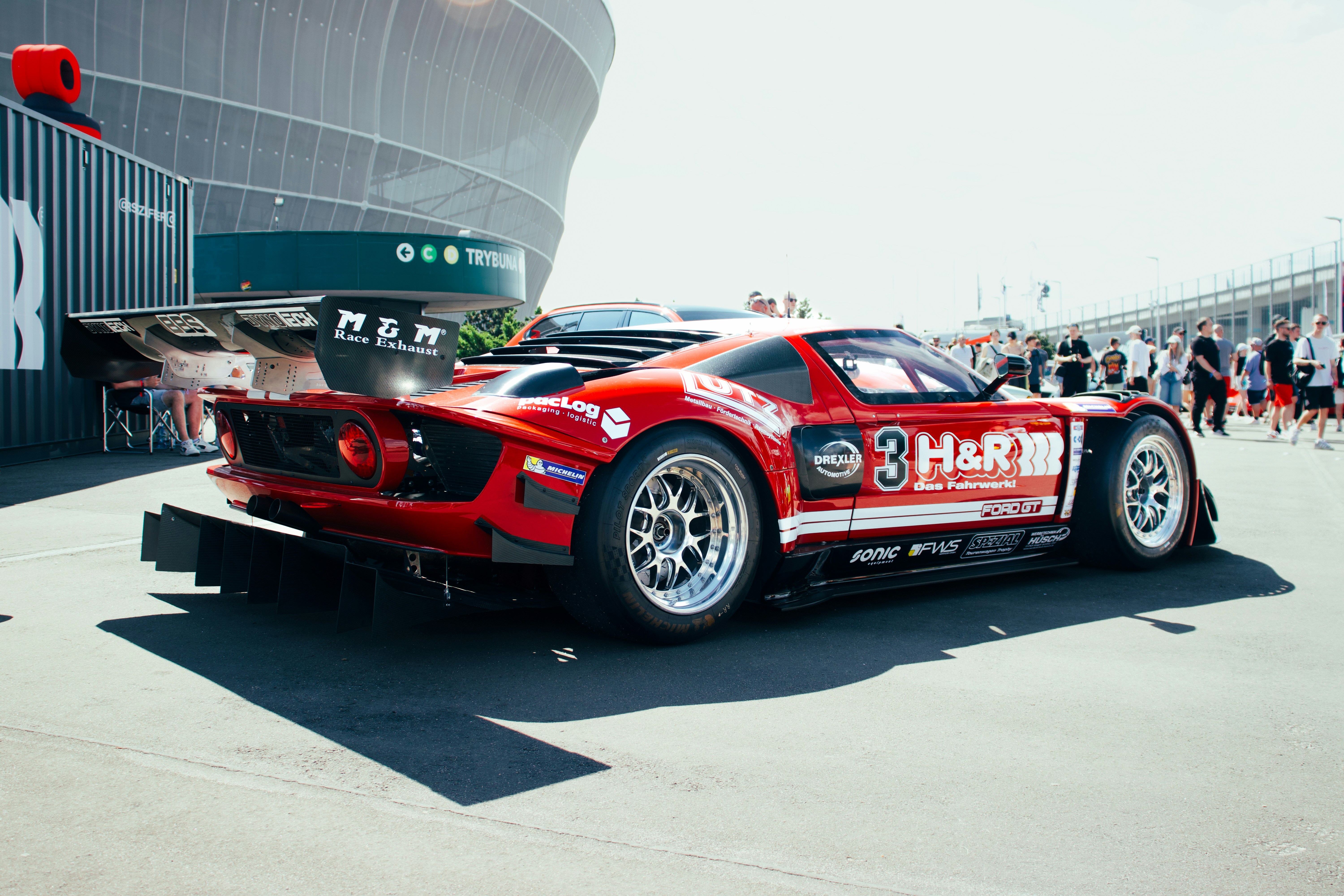 Red racing heritage meets modern pavilion: a gull-wing stance on tarmac