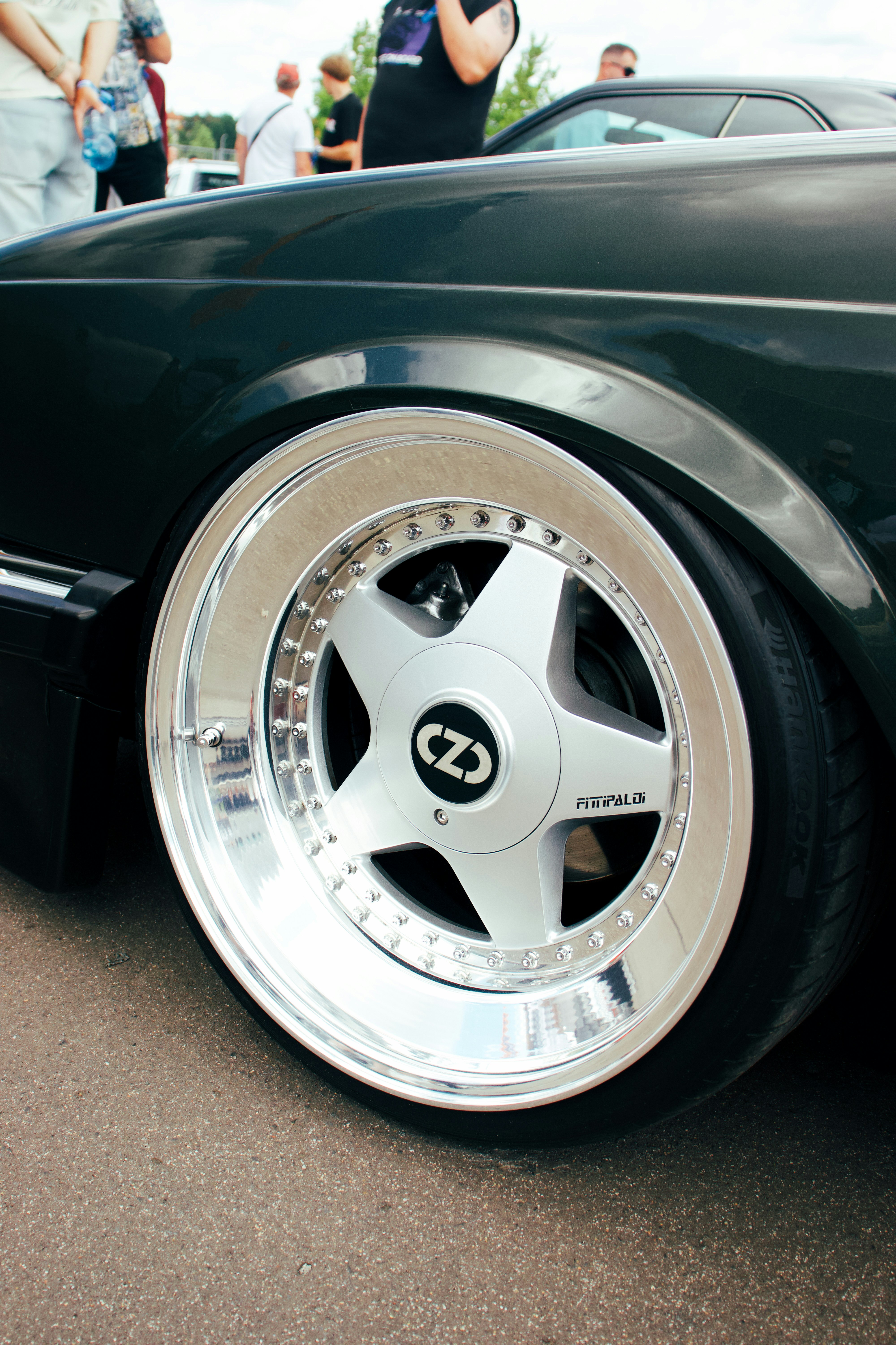 Chrome Crown: A Sharp Glimpse of a Custom Wheel in a Car Meet