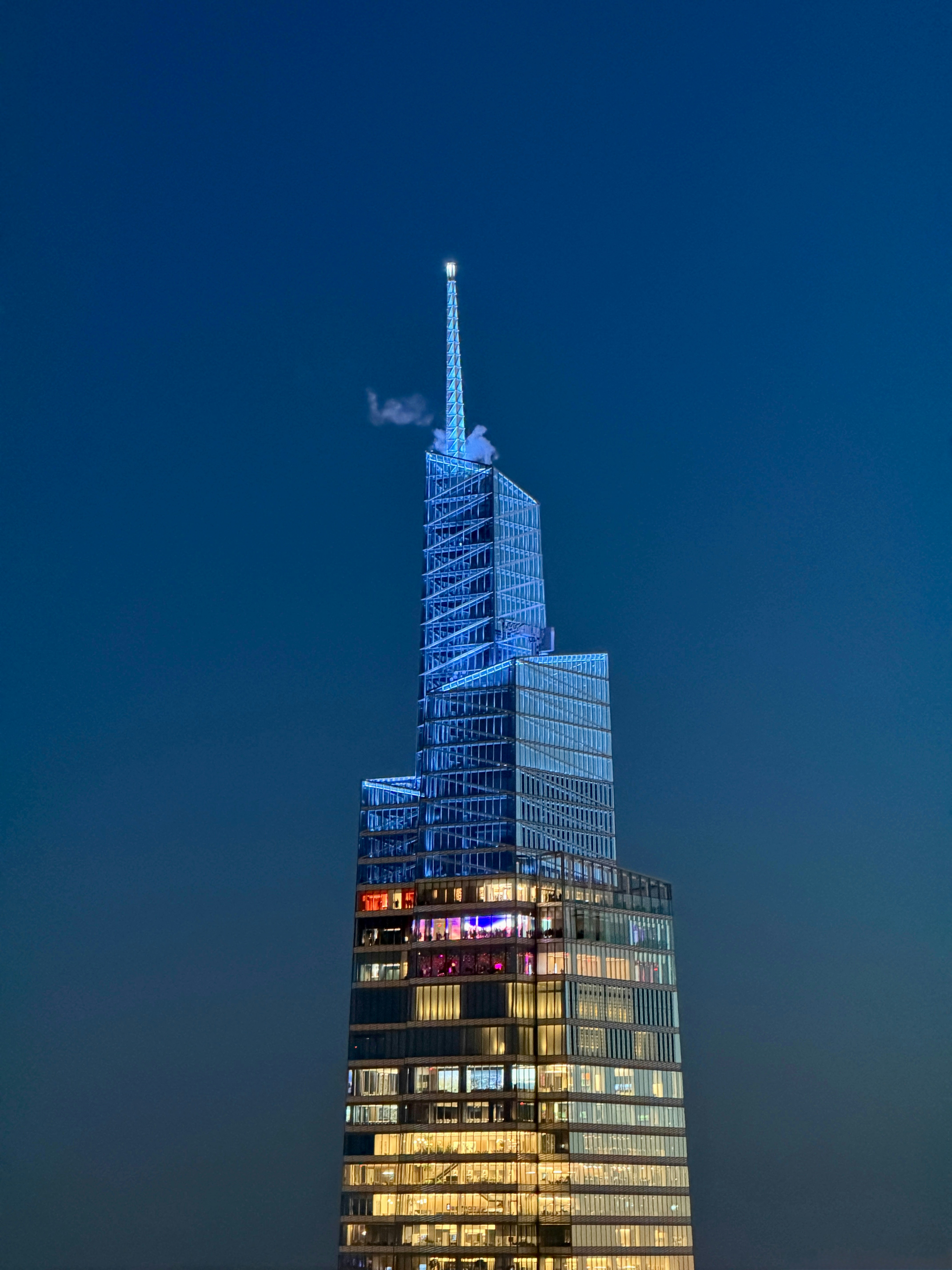 Skyscraper Apex: Blue light tracing the tower's ascent into night