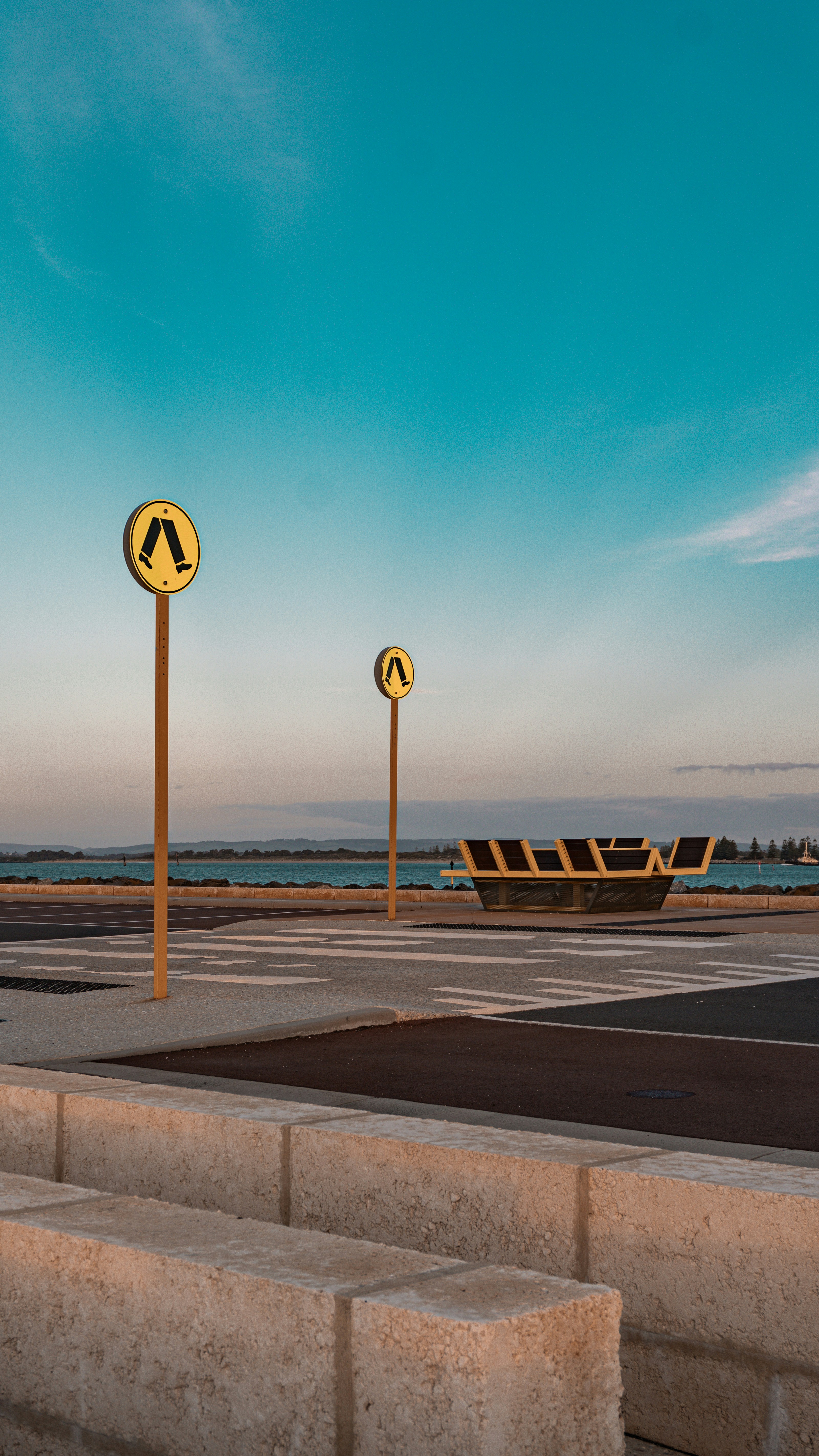 Quiet Pierline: Signposts and a Waiting Bench by the Sea