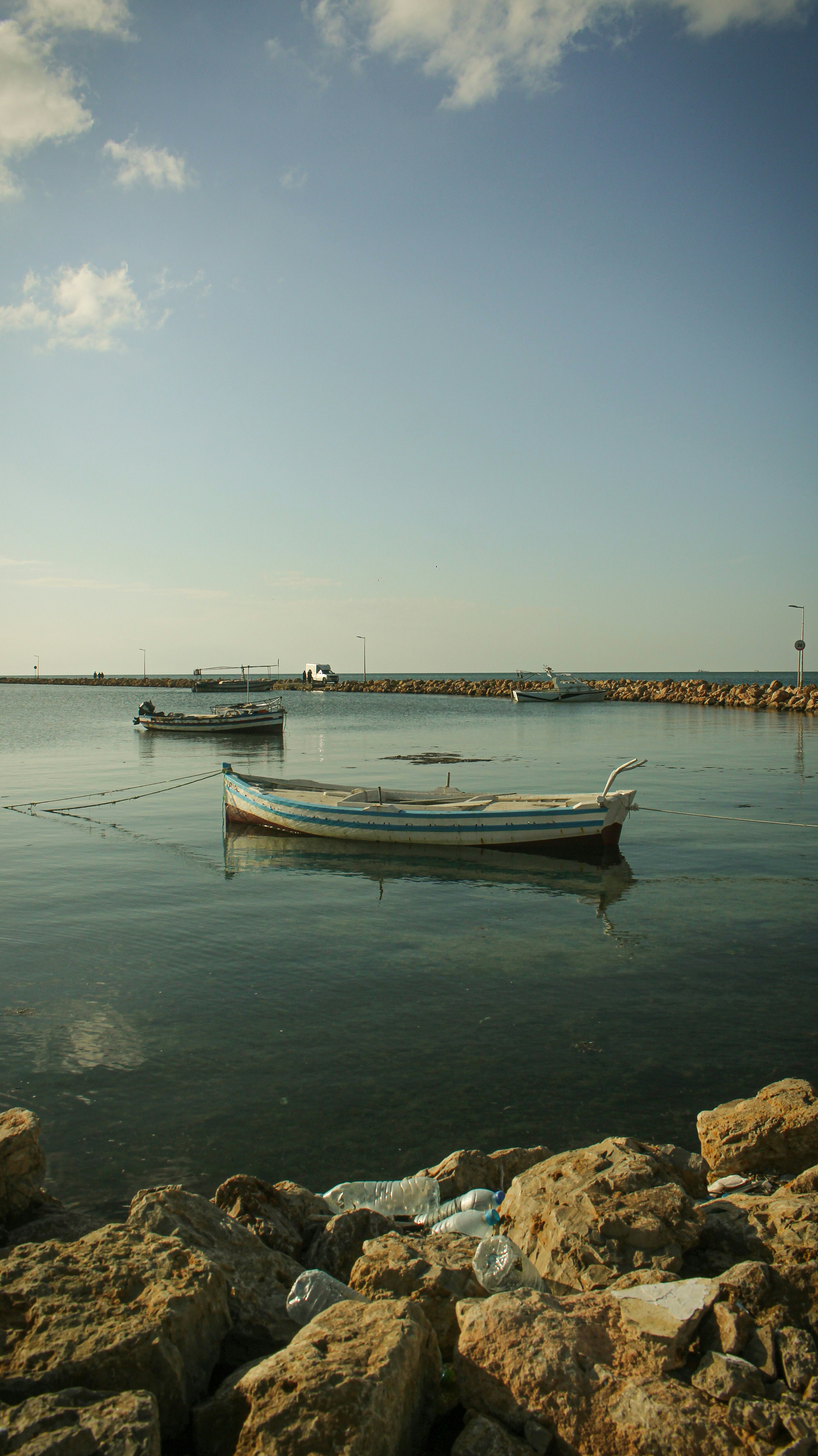 Boats at Rest: Quiet Harbor with Rocky Foreground